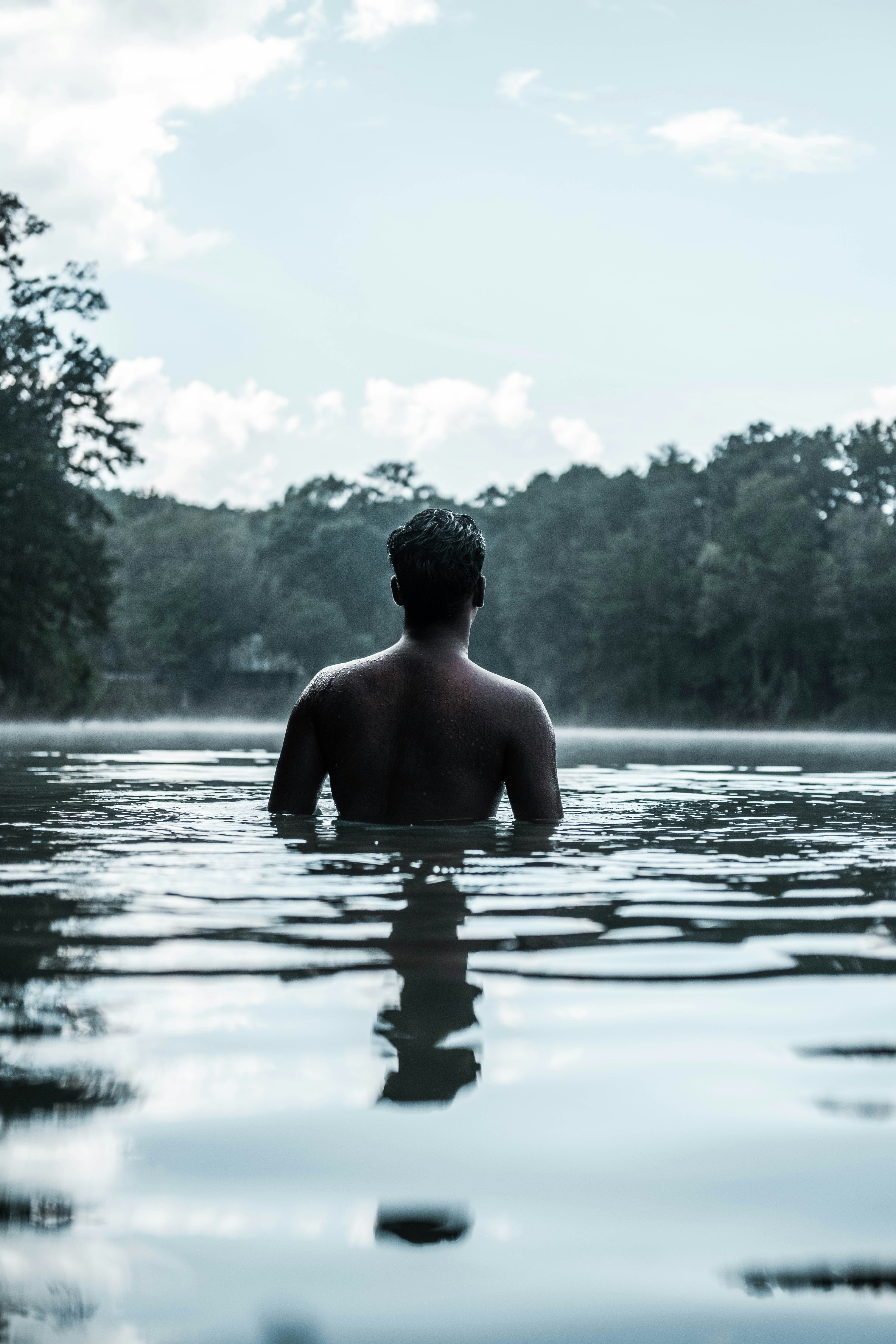 Back to the Quiet: A Man Submerged in a Dawn-lit Lake