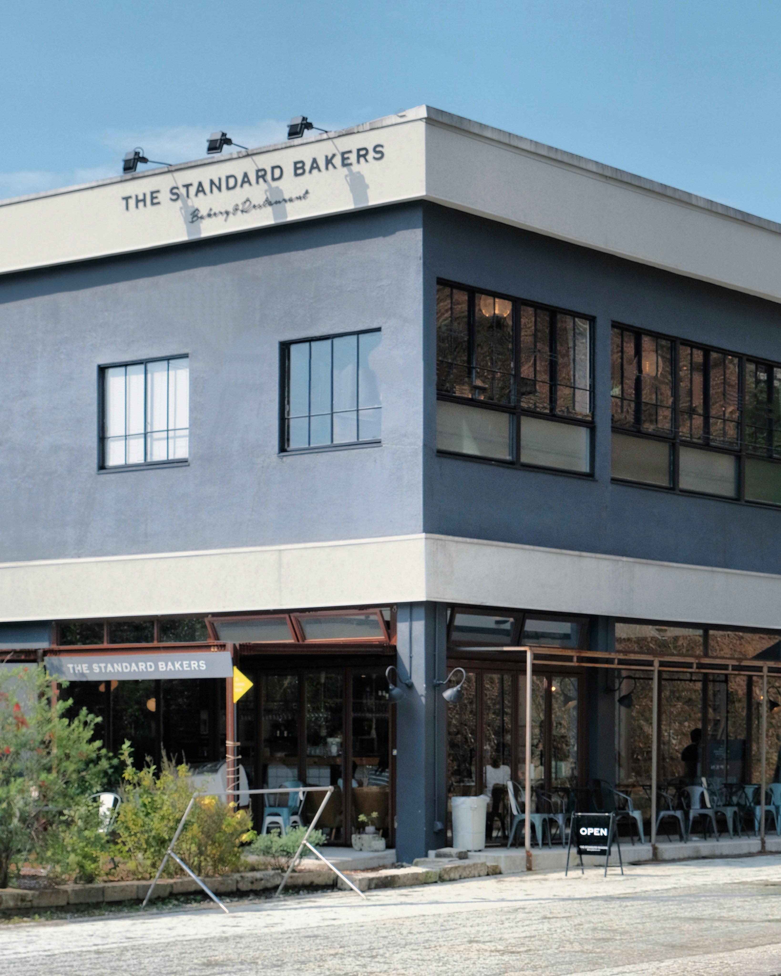 Charming bakery facade featuring large windows and an inviting entrance, showcasing the establishment's name prominently. Open sign enhances the welcoming atmosphere.