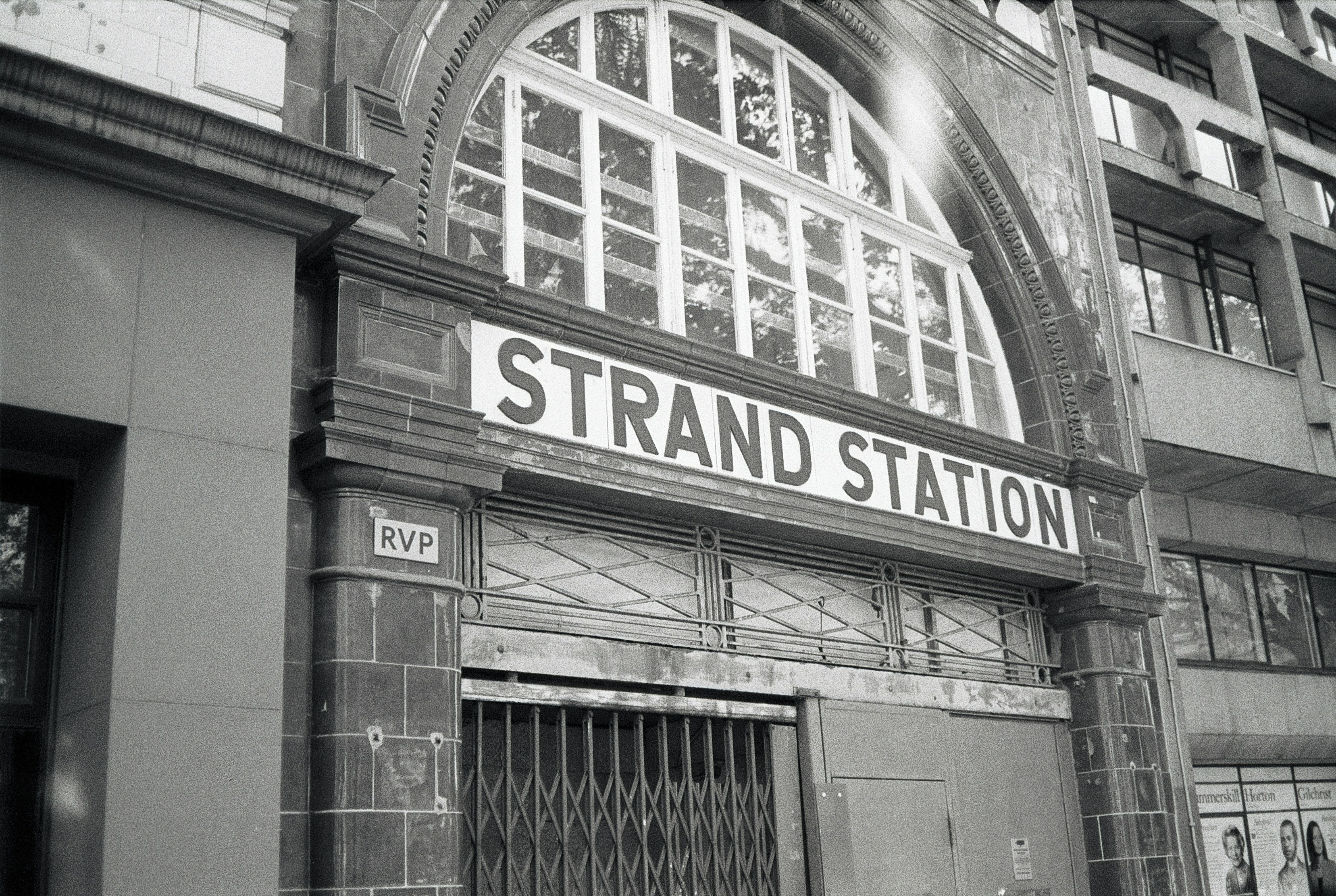 A black and white photo of a building with a sign that says strand ...