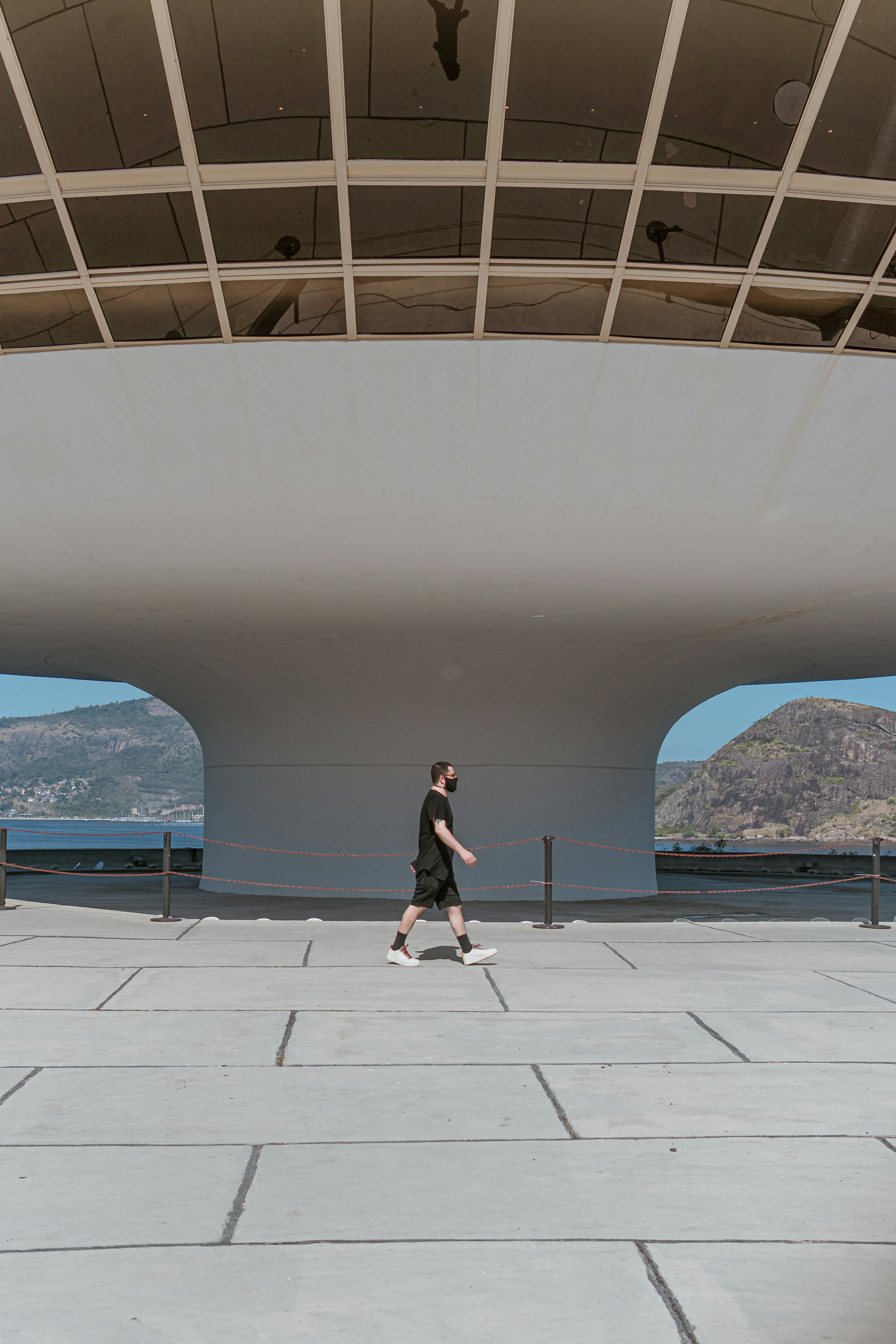 Under the Harbour Canopy: a lone jogger strides beneath a sweeping seaside pavilion
