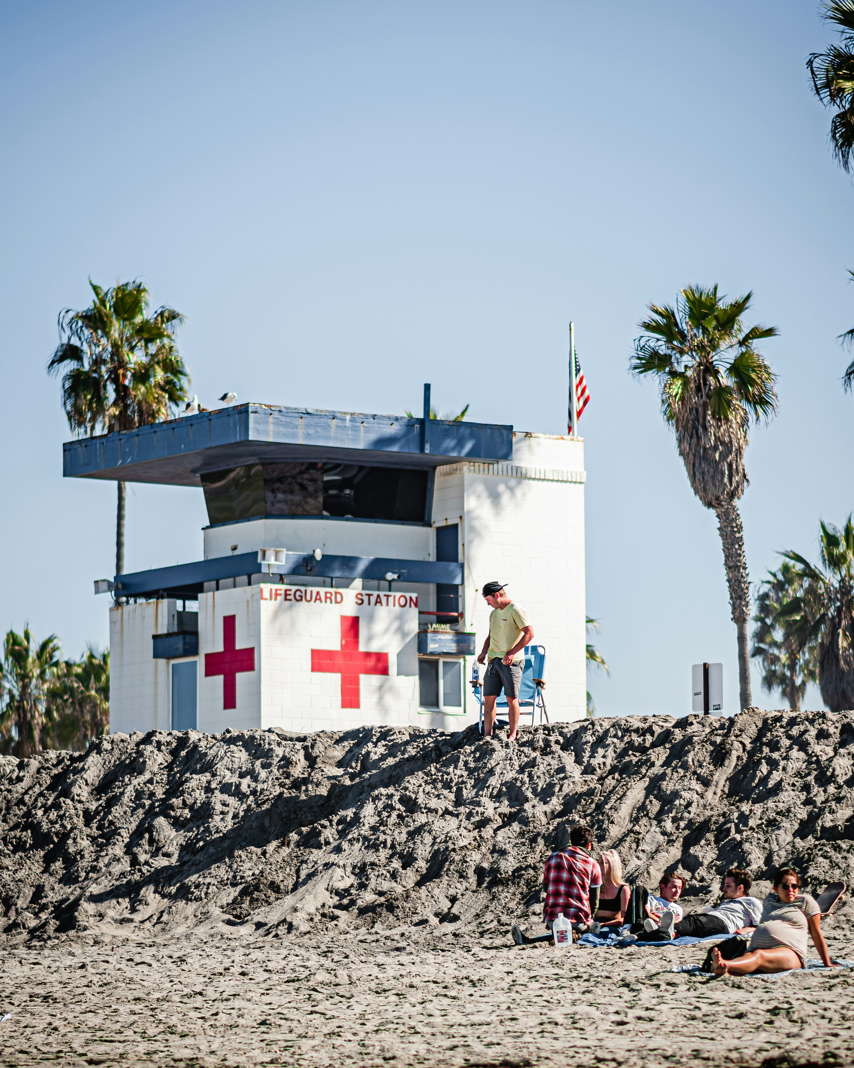 Dune Sentinel: A Lifeguard Station Framed by Palms and a Bright Coastal Sky