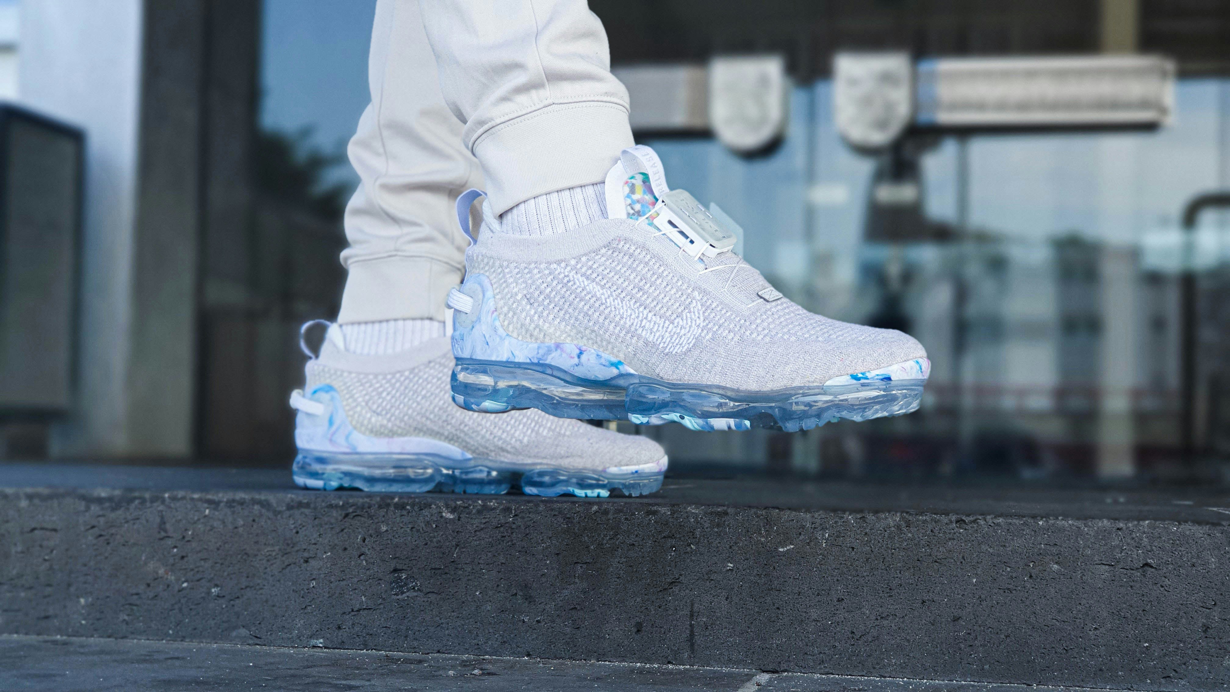 Weightless Step: White-knit Sneakers Hover Over a City Stair