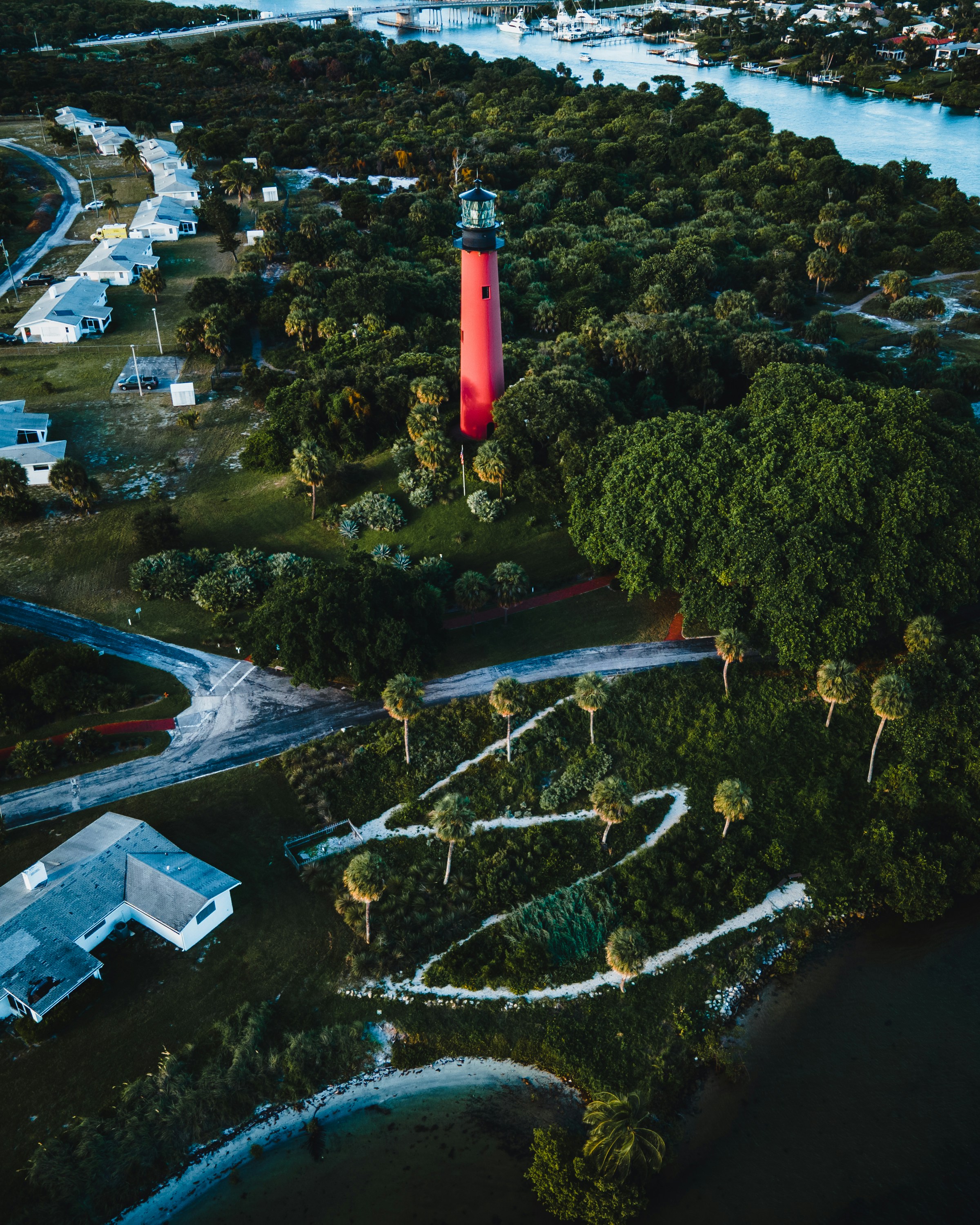 Red and black lighthouse near green trees during daytime photo – Free ...