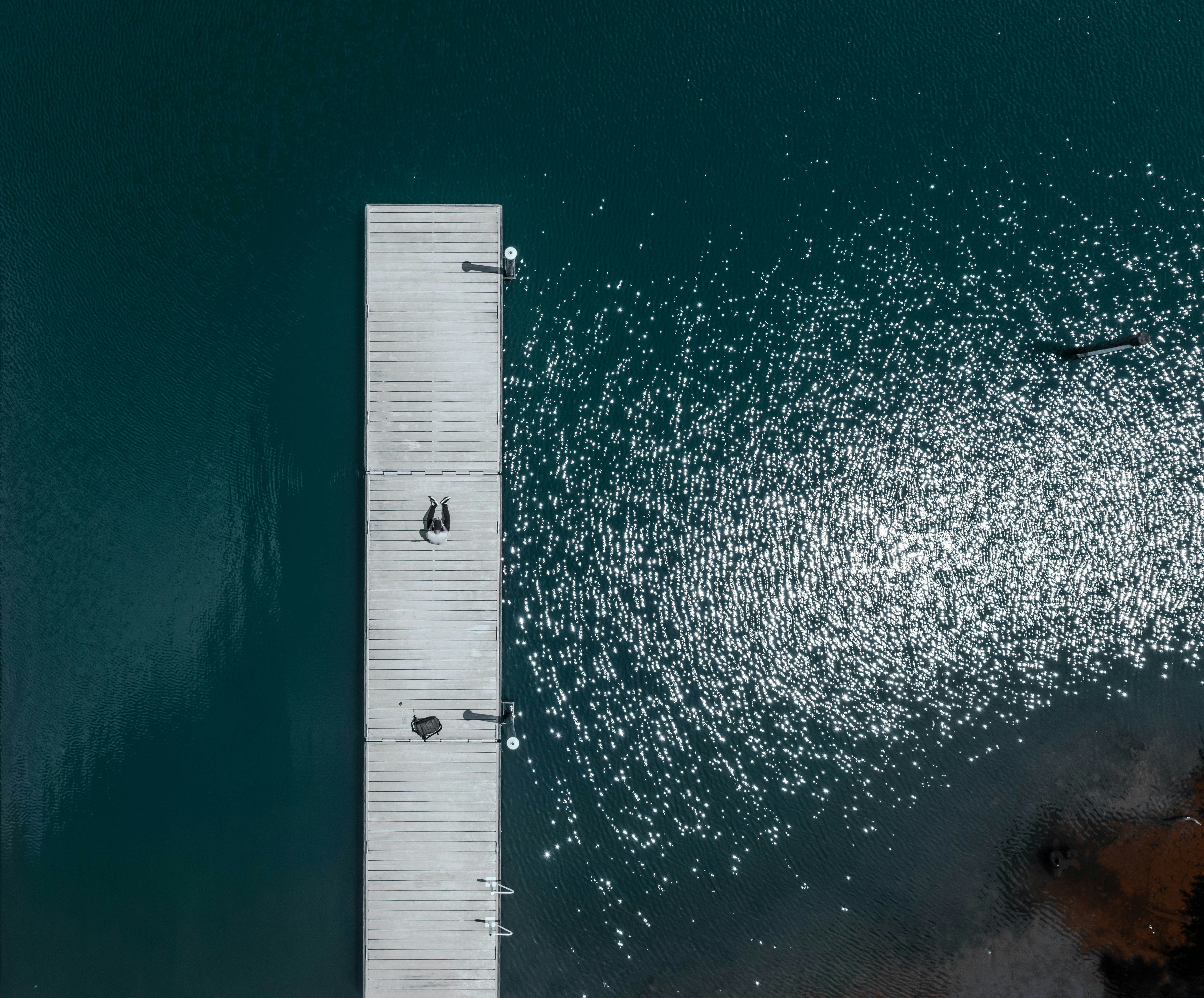 Elevated Pier: A Symmetrical Dance of Turquoise Water and Silver Planks