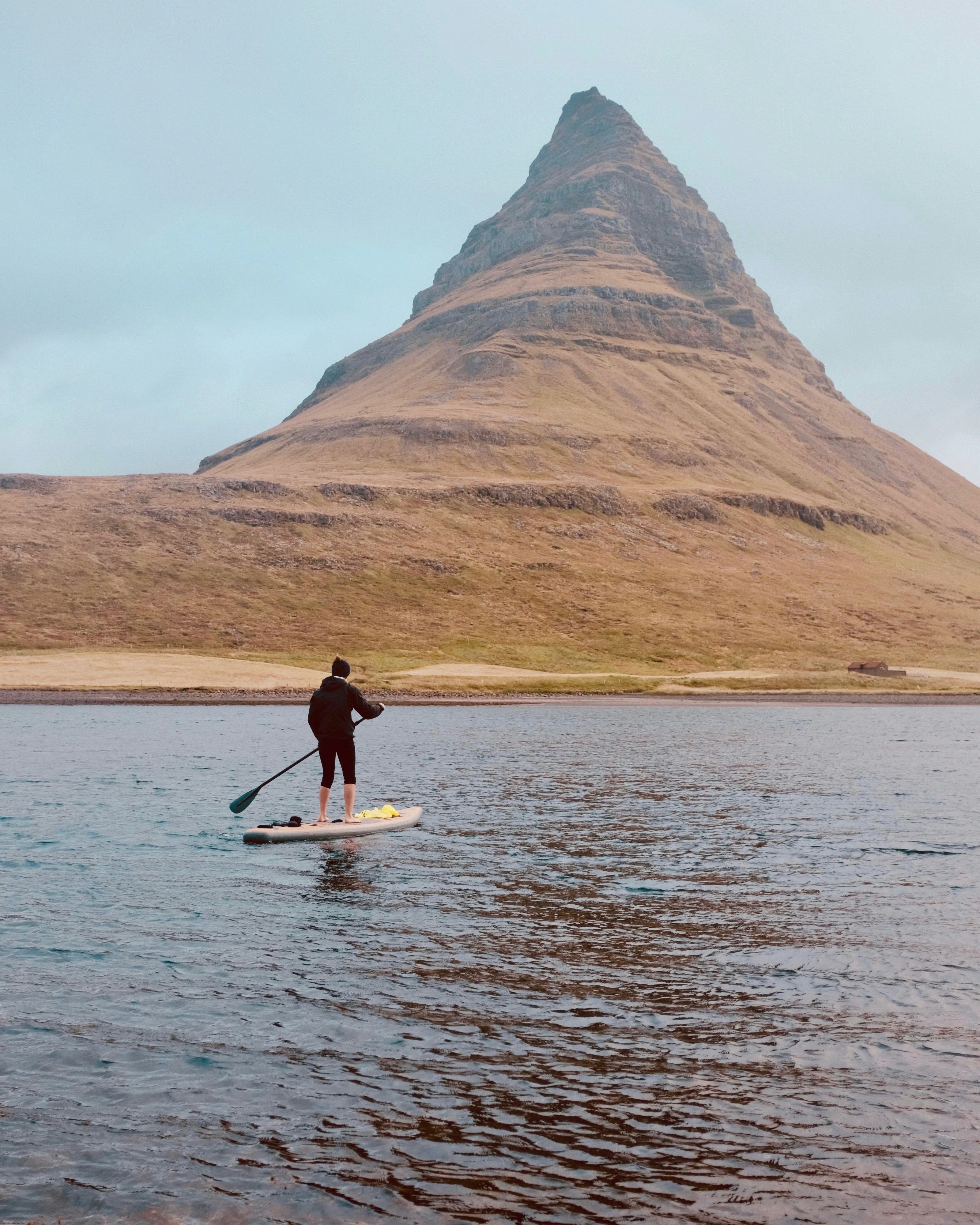 Solitary Paddleboarder Beneath a Pyramid Peak on Quiet Waters