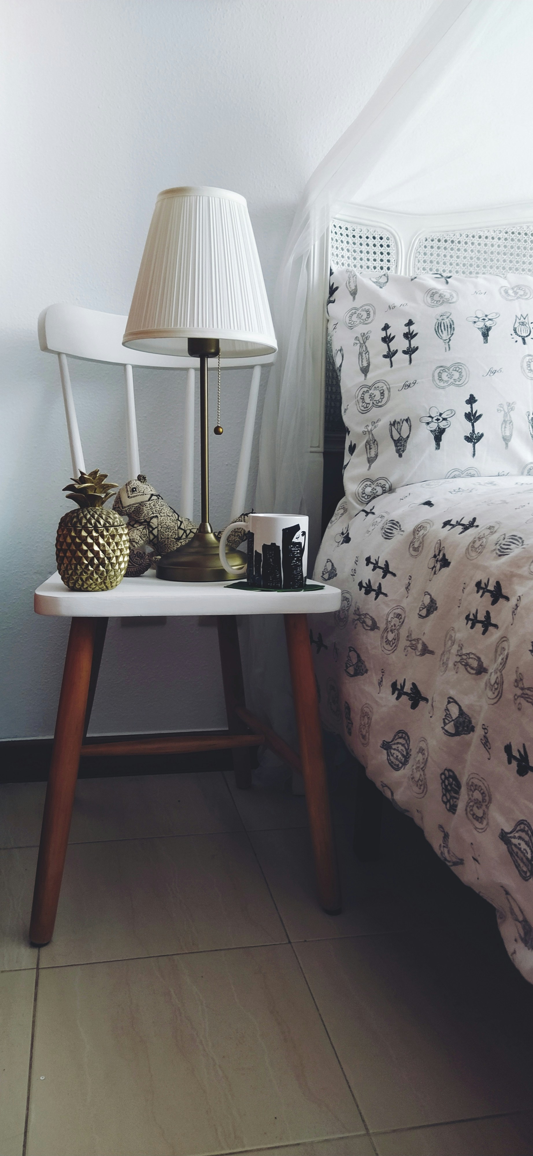 Cozy Corner: A Bedside Tableau with Pineapple Lamp and Patterned Bedding