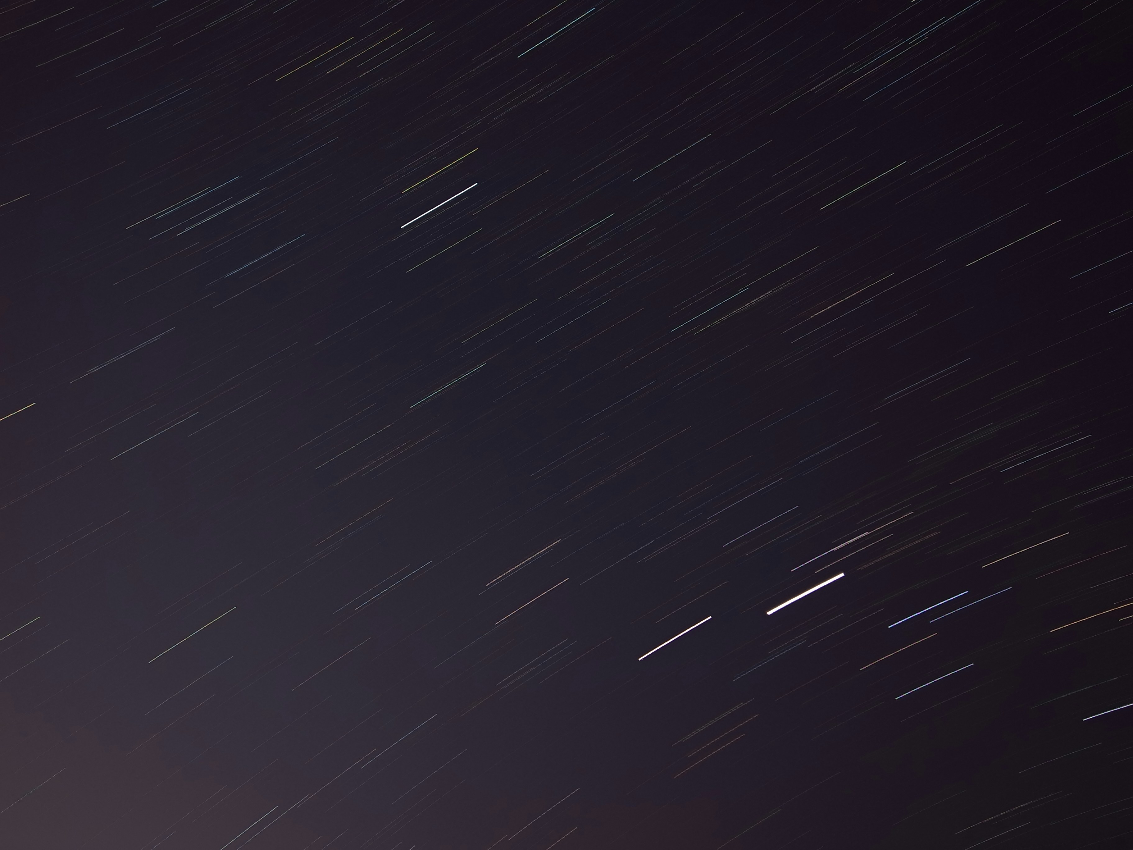 Long exposure captures the movement of stars across the night sky, creating streaks of light against a dark backdrop.
