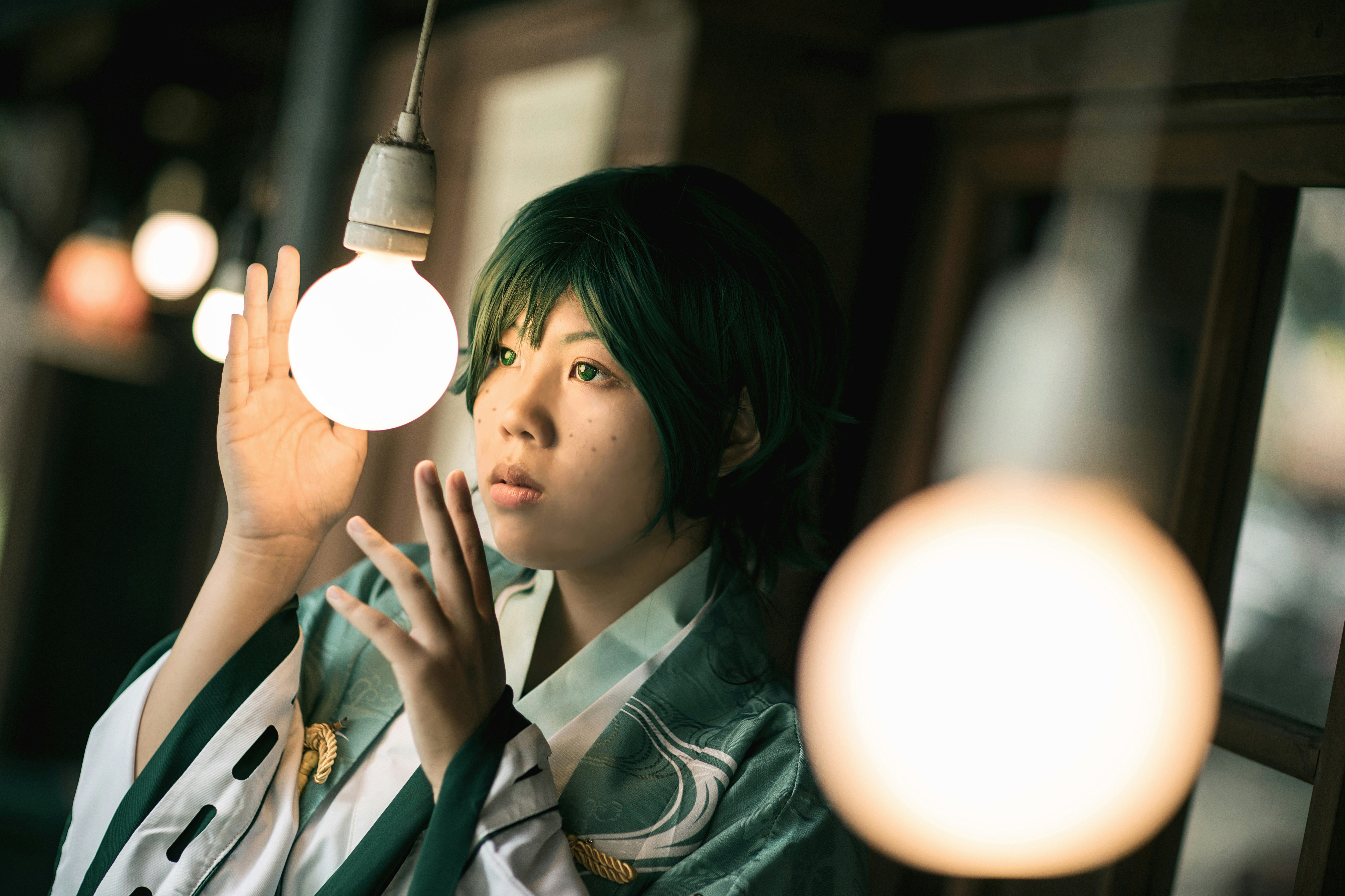 Woman in green and white school uniform holding white light bulb photo ...