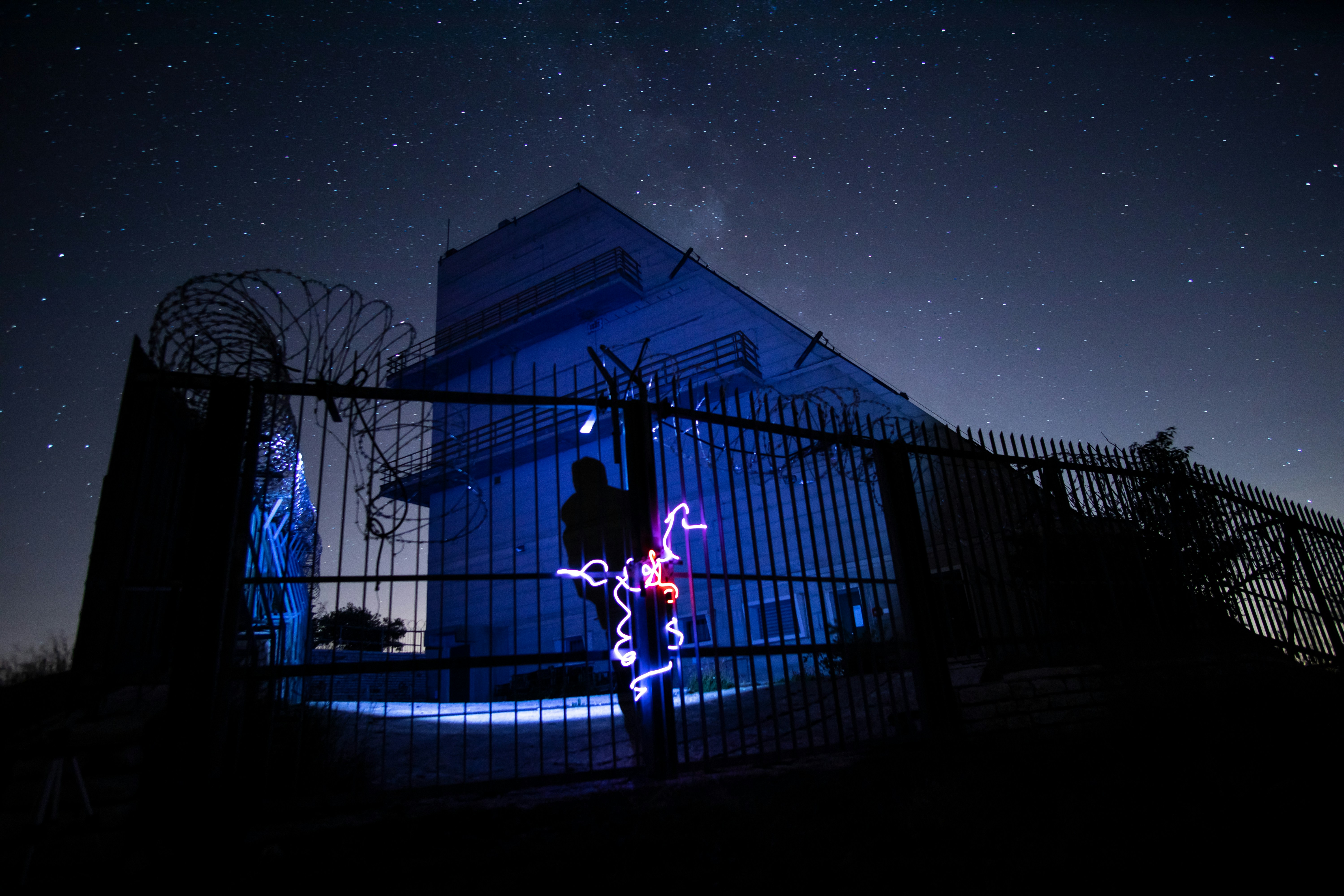 man in red jacket standing near building during night time