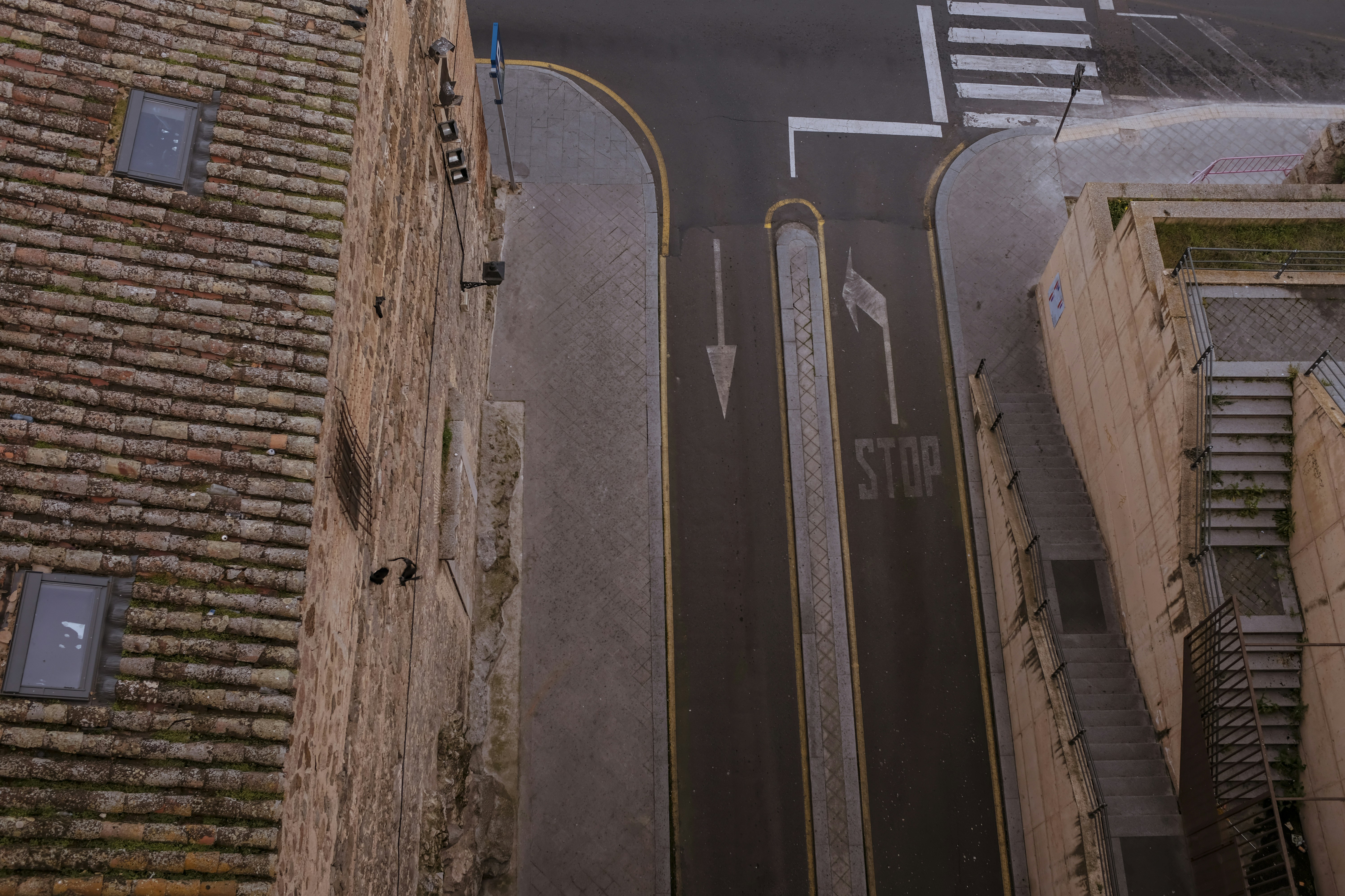 Aerial Crossroads: Brick-Walled Edges Framing a Quiet City Artery