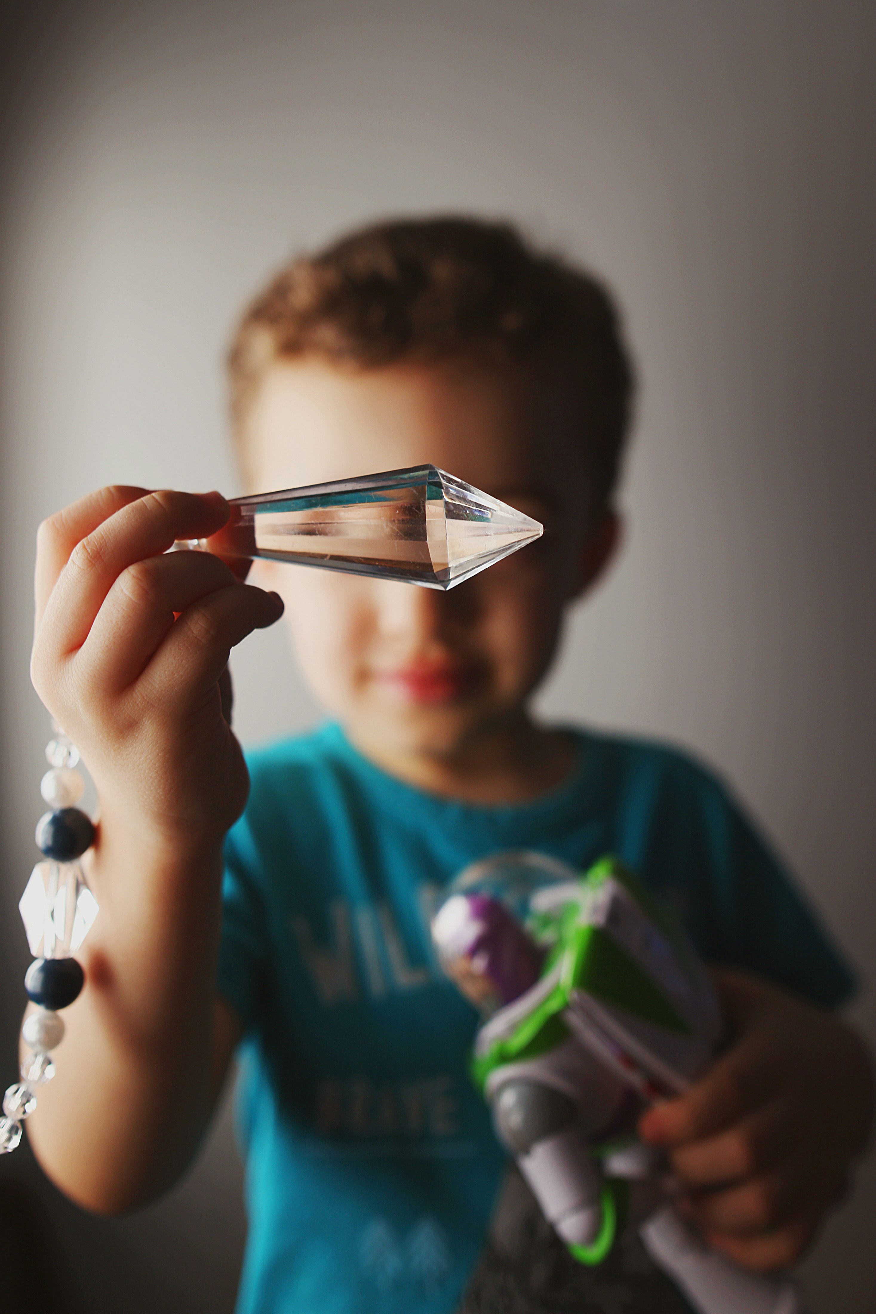 Prism of Play: Child Magnifying a Crystal Sculpture