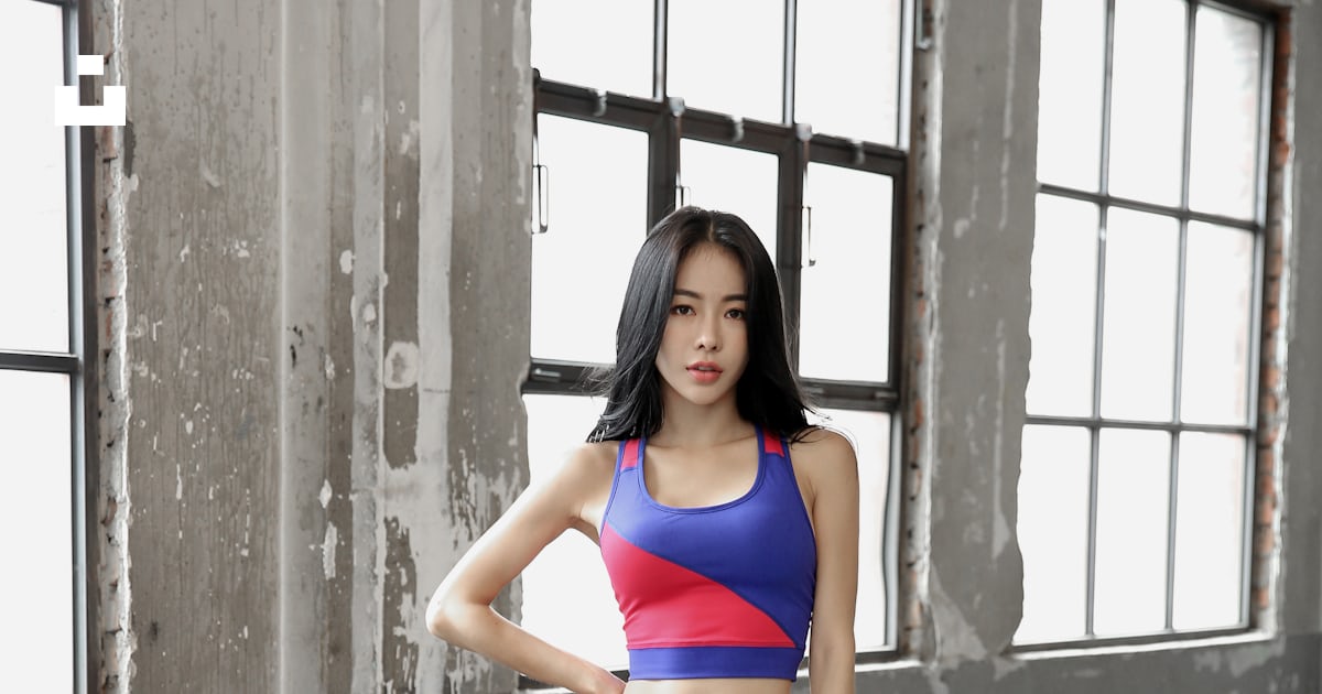 파란색과 주황색 스포츠 브래지어와 복도에 서 있는 파란색 레깅스를 입은 여자 사진 Unsplash의 무료 사람의 이미지