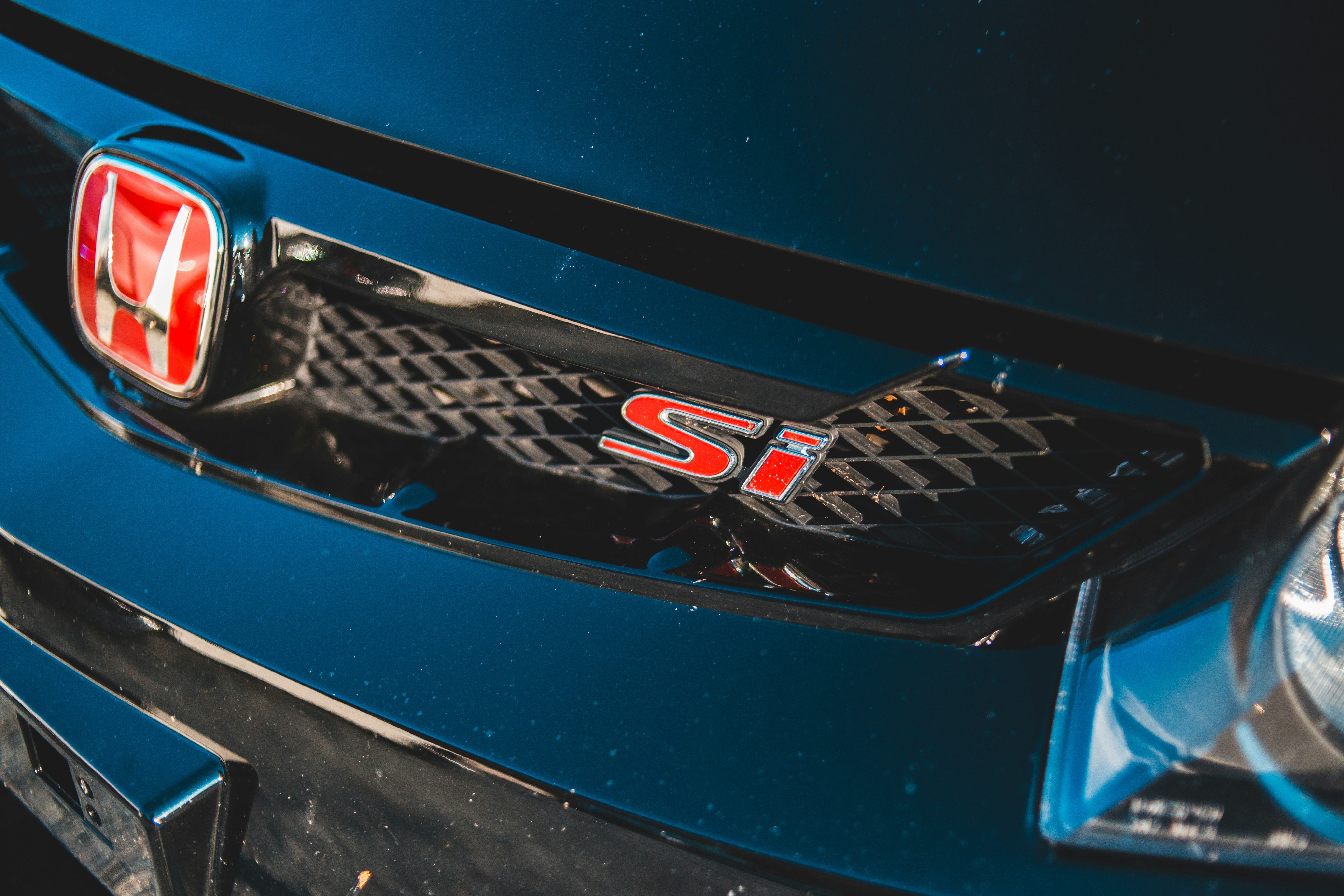 Close-up of the Honda SI badge on a sleek black car, showcasing its sporty design and attention to detail.