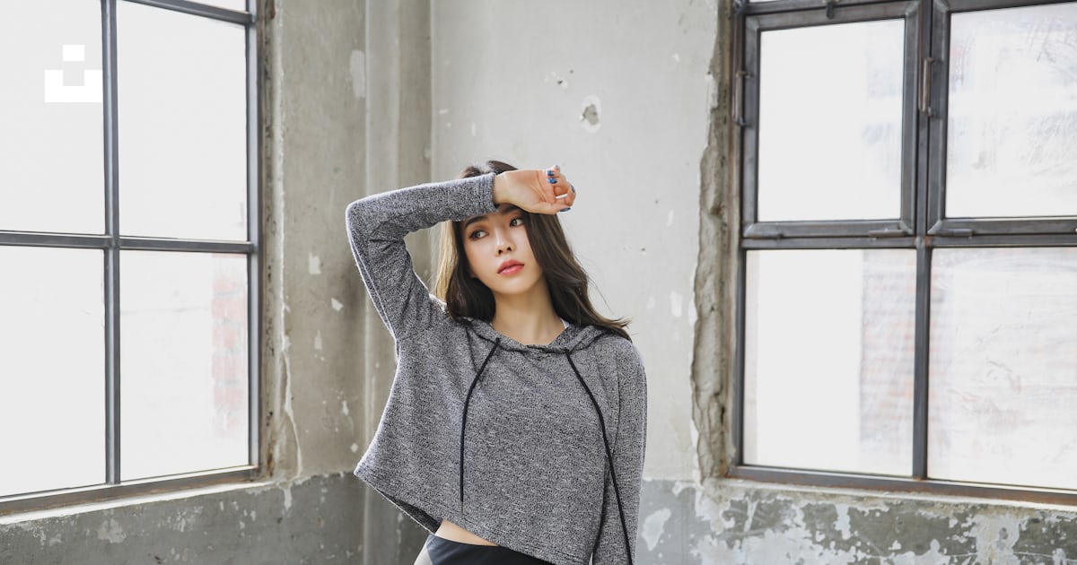 회색 스웨터와 검은 바지를 입은 여자가 창가에 서 있다 사진 Unsplash의 무료 회색 이미지
