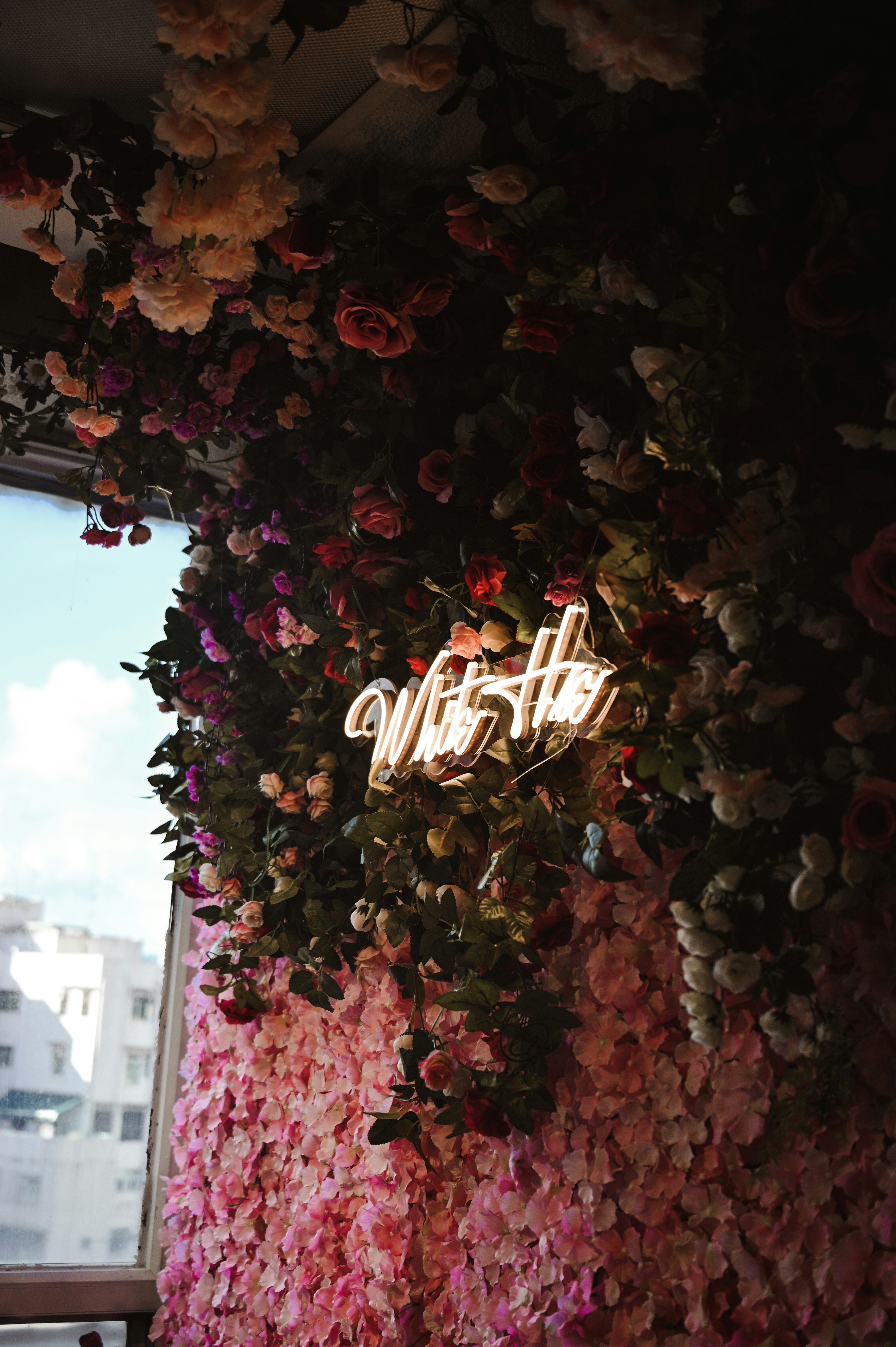 Neon Script Glowing Through a Velvet Floral Wall