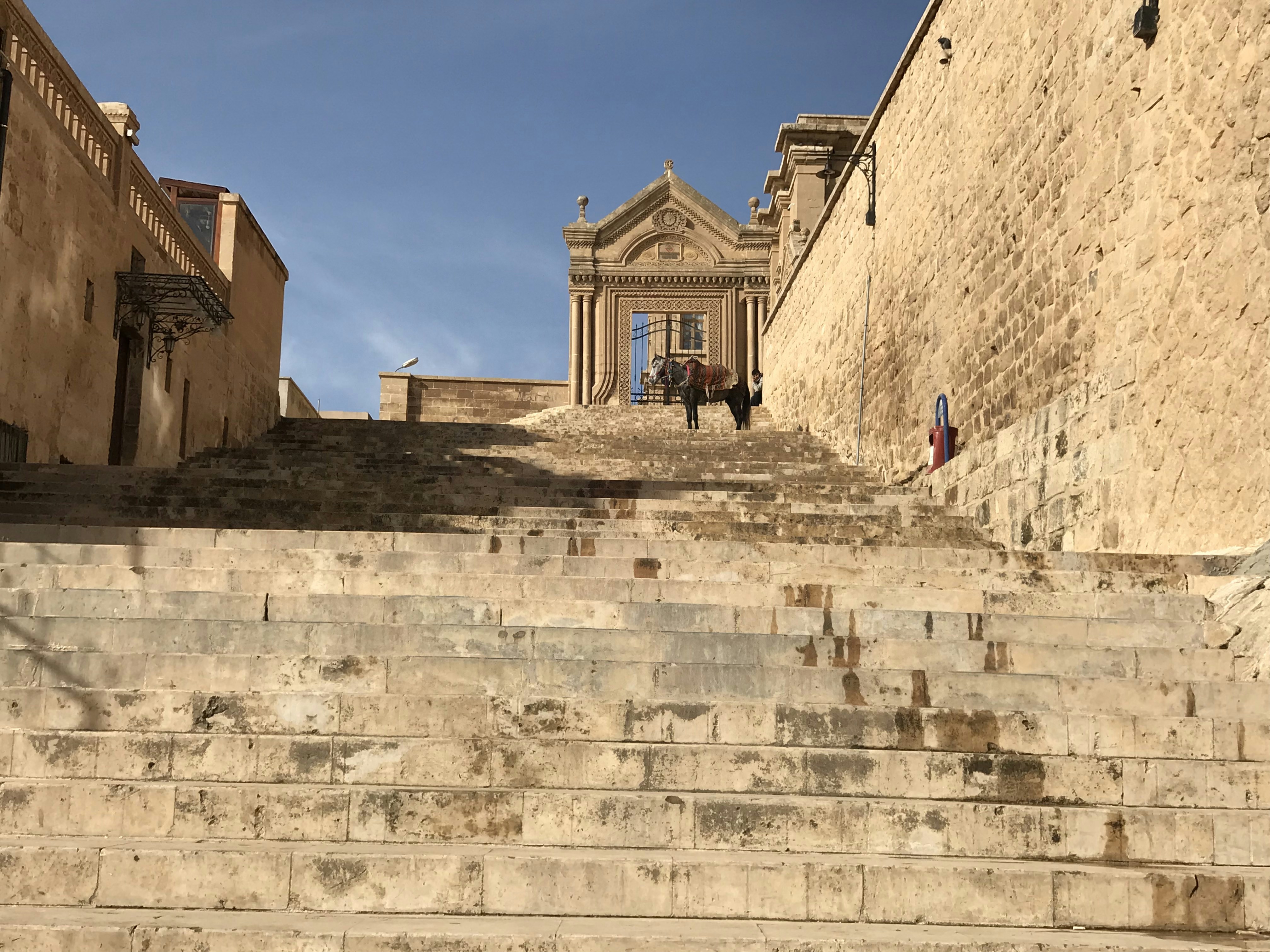 Stone staircase leading to a historic building under a clear blue sky.
