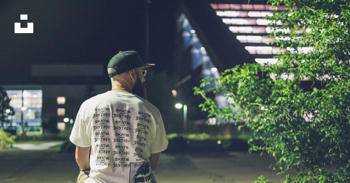 Hombre Con Camiseta Blanca Y Gorra Negra Sentado En Un Banco De Madera