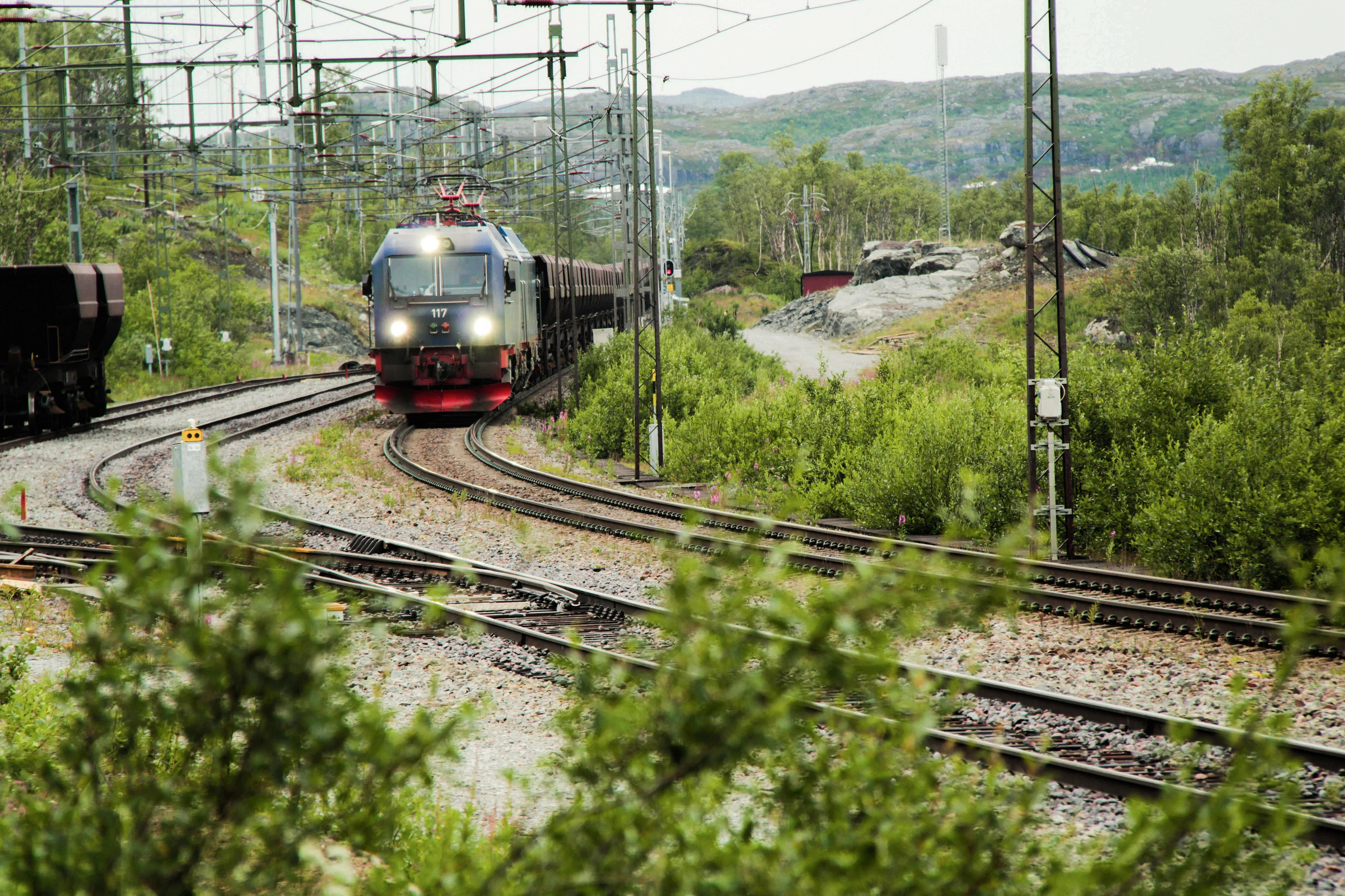 Green and red train on rail tracks during daytime photo – Free ...