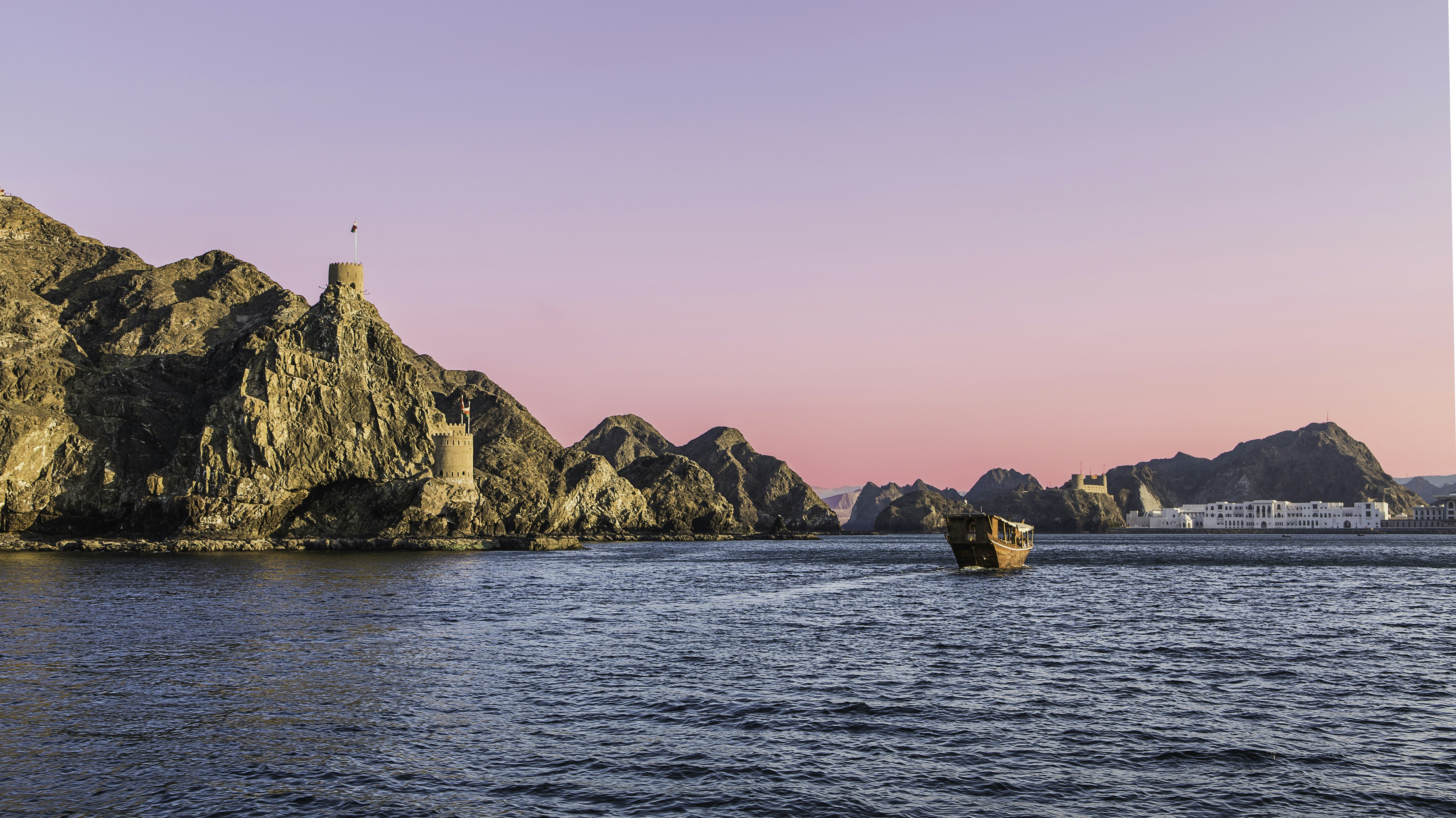 Küste Oman | white and brown lighthouse on brown rock formation beside body of water during daytime