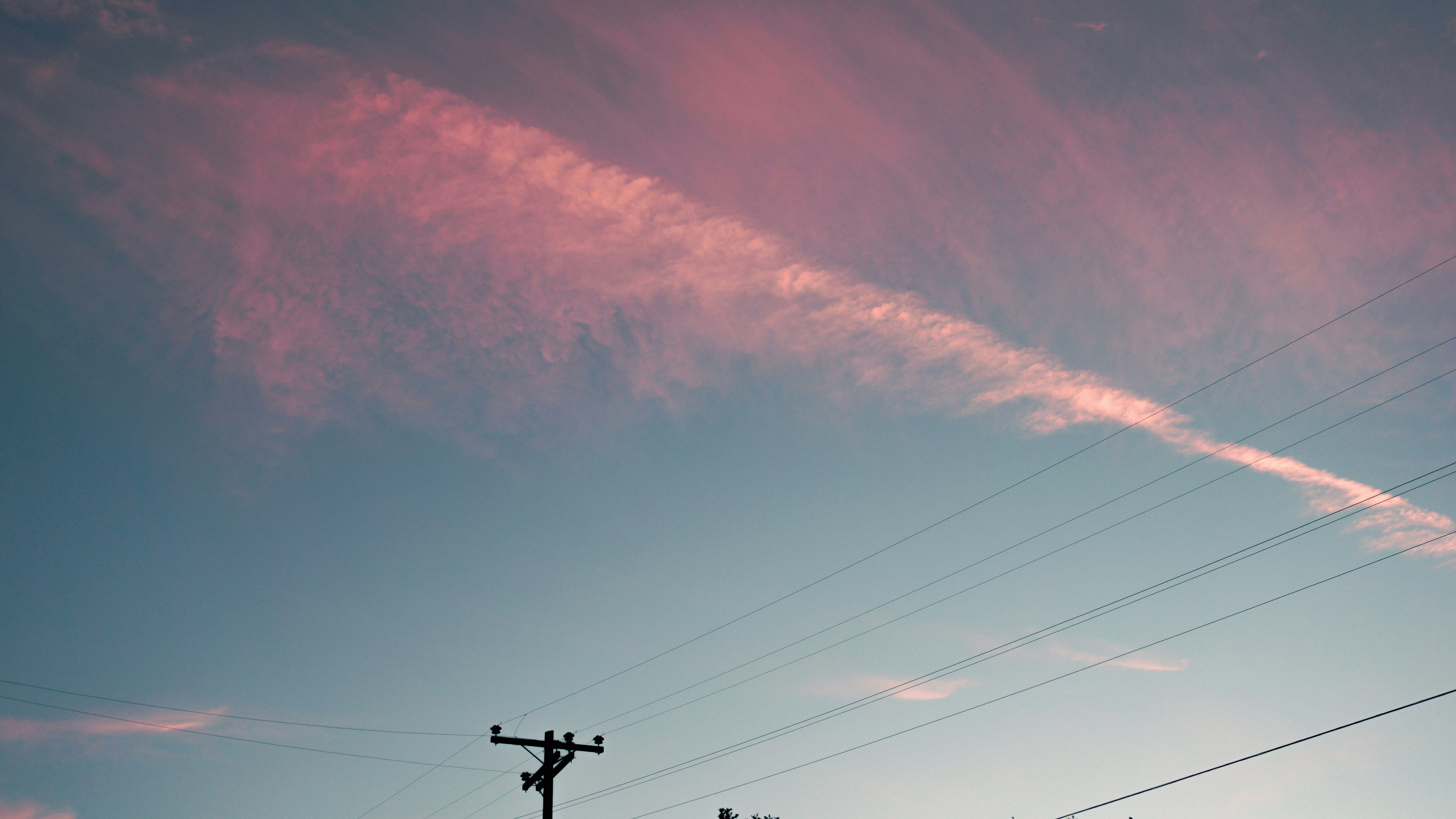 Stray power lines vanish into a pastel sunrise