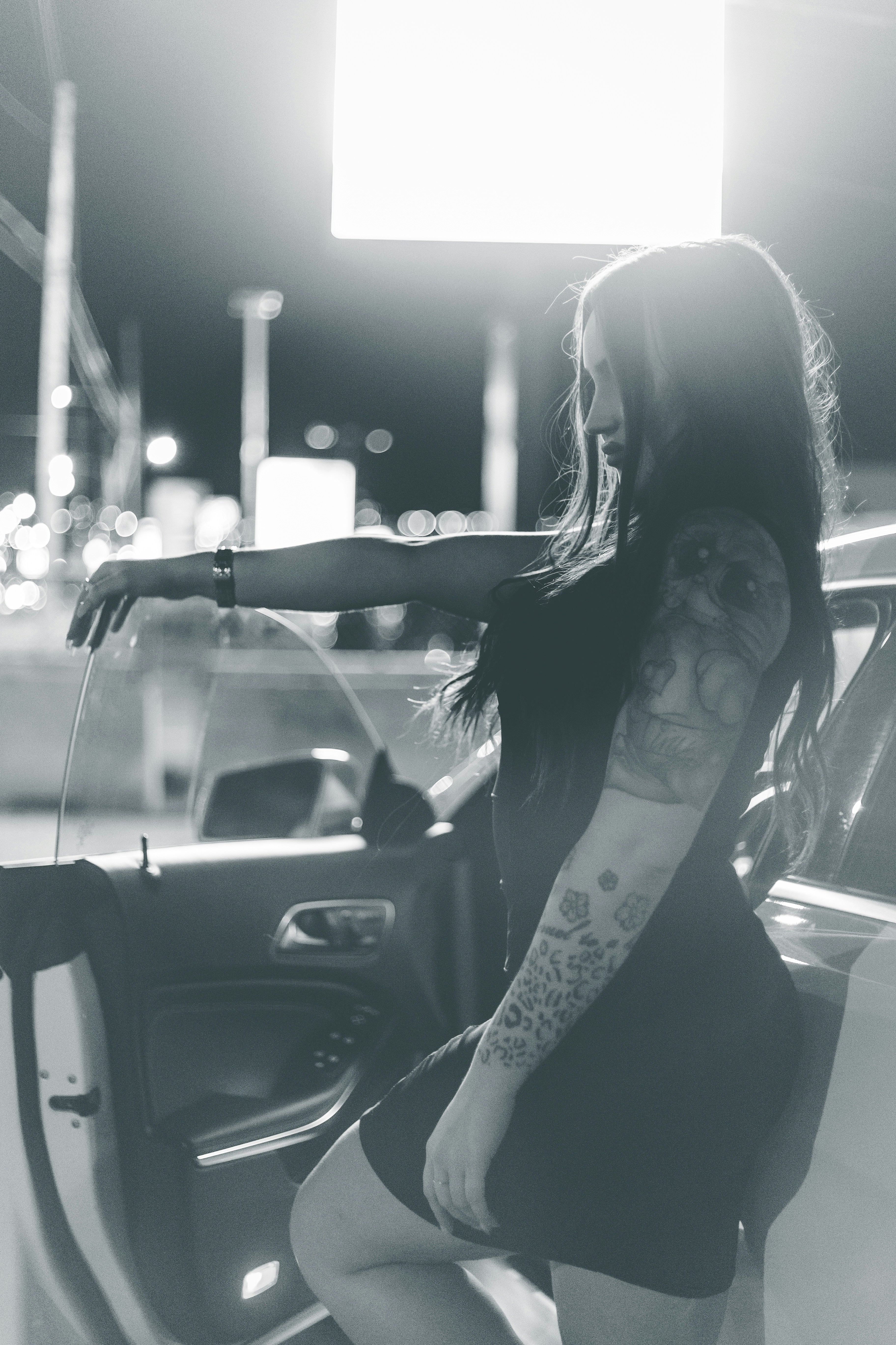 Neon Night Pose: Tattooed Silhouette by an Open Car Door