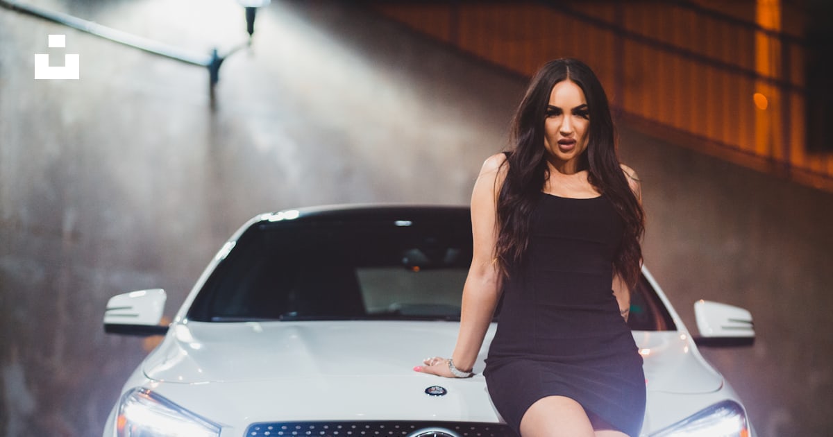 白いメルセデスベンツの車に座っている黒いタンクトップと青いデニムのショートパンツの女性の写真 Unsplashの自動車の無料画像