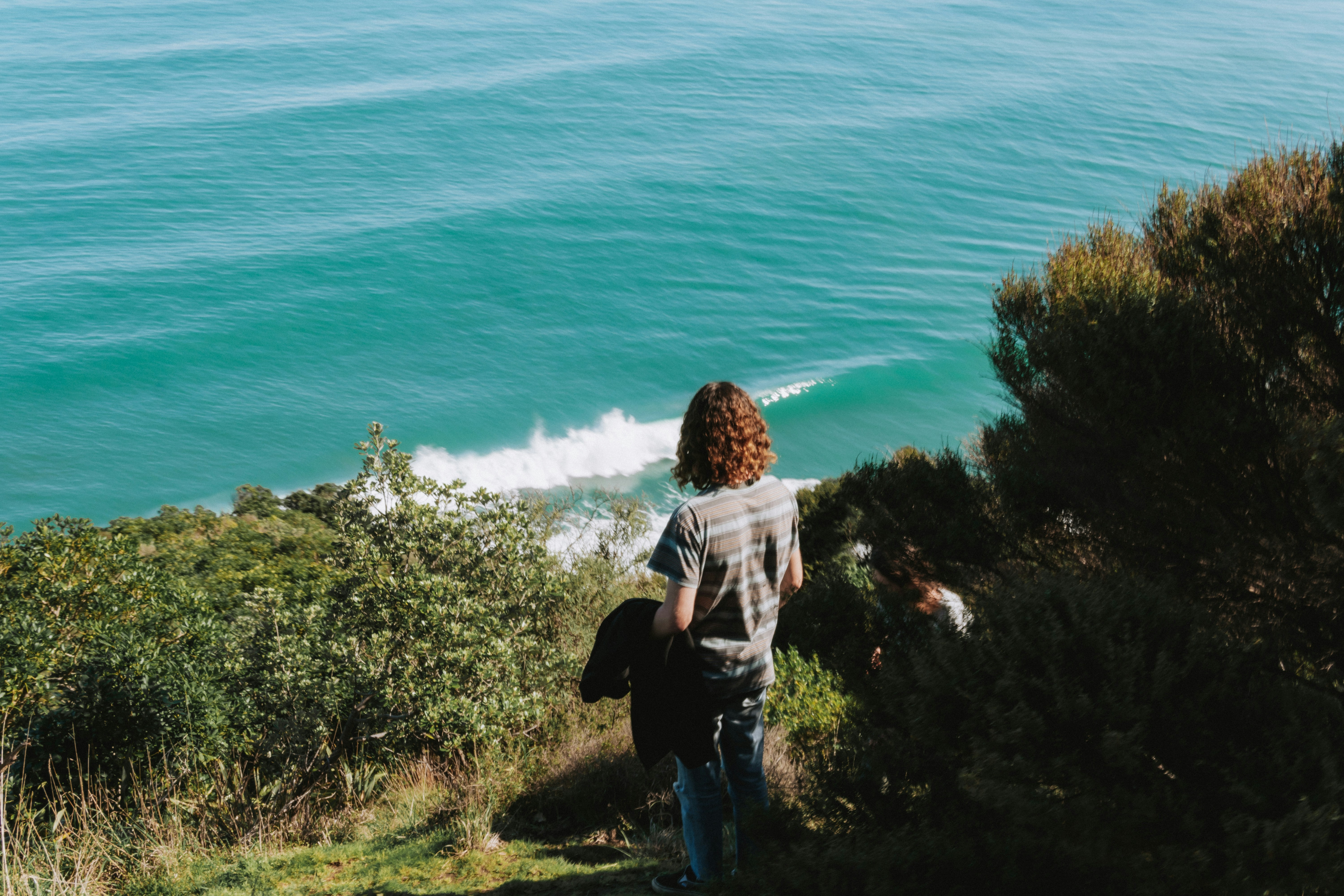 Cliffside Gaze: A Quiet Moment Above the Turquoise Sea