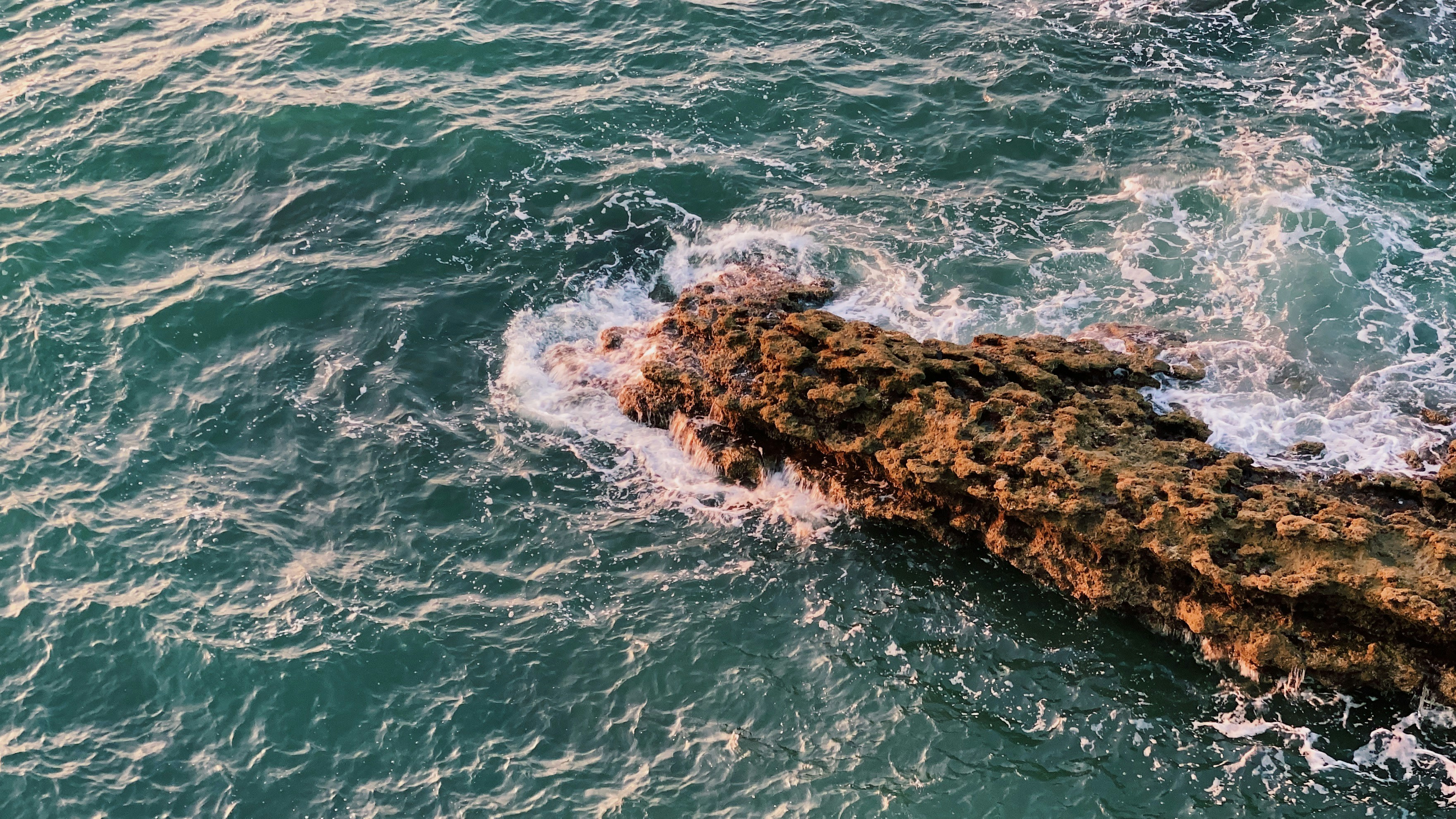 Ocean's Embrace: Waves Meet Rocky Outcrop