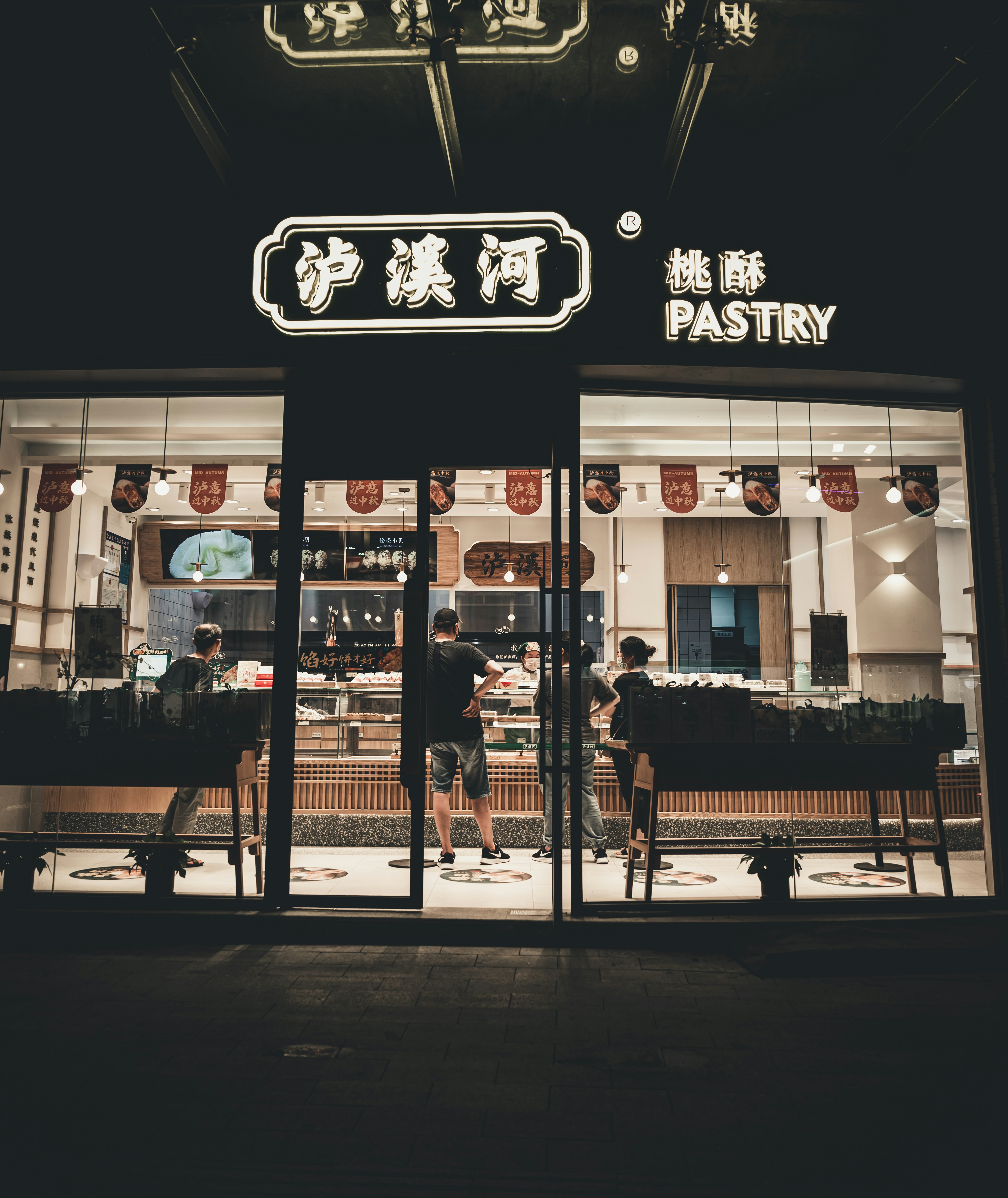 People sitting on bench in front of store during night time photo ...