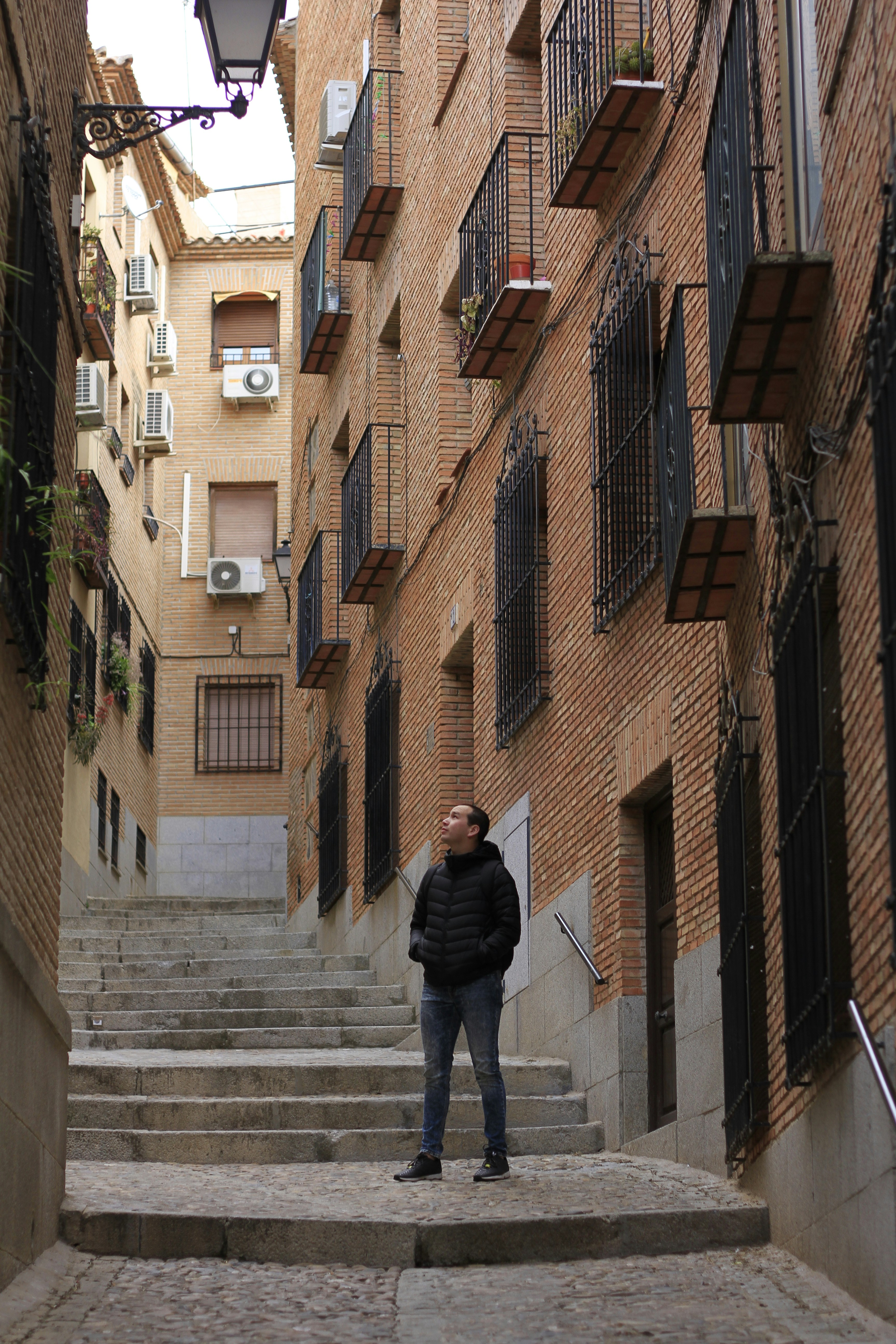 Urban ascent: a solitary figure anchors the brick stairwell
