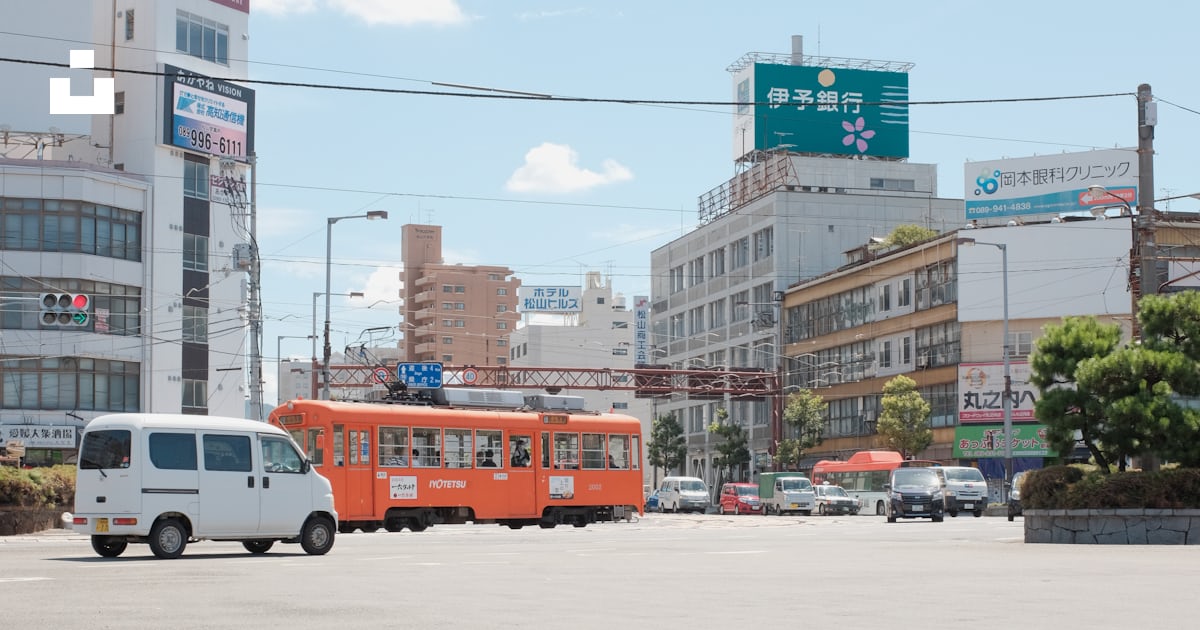 낮 동안 도로에 흰색과 주황색 버스 사진 Unsplash의 무료 마쓰야마 이미지