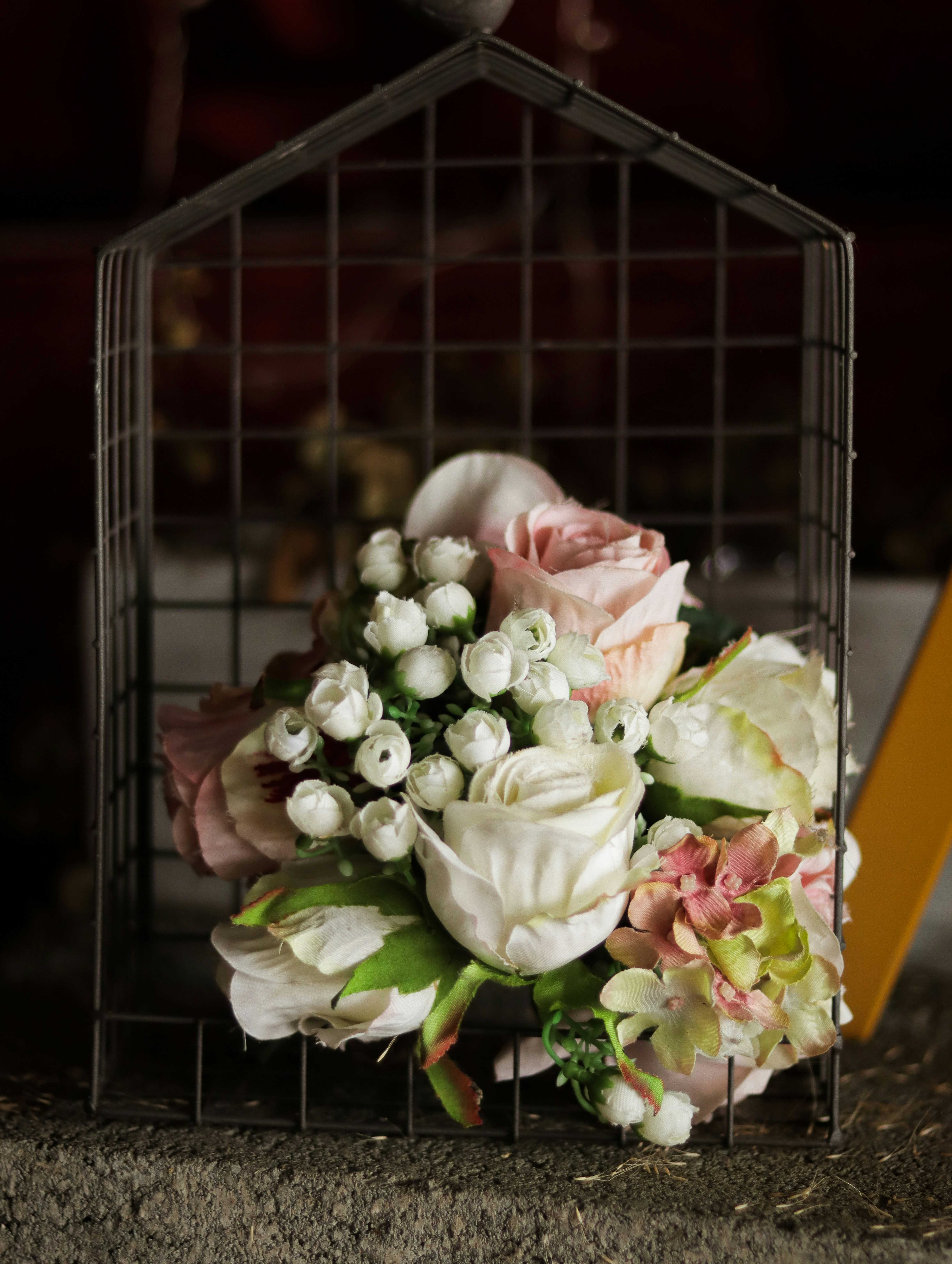 Bouquet in a Metal Cage: Soft Florals Against Rustic Shadow