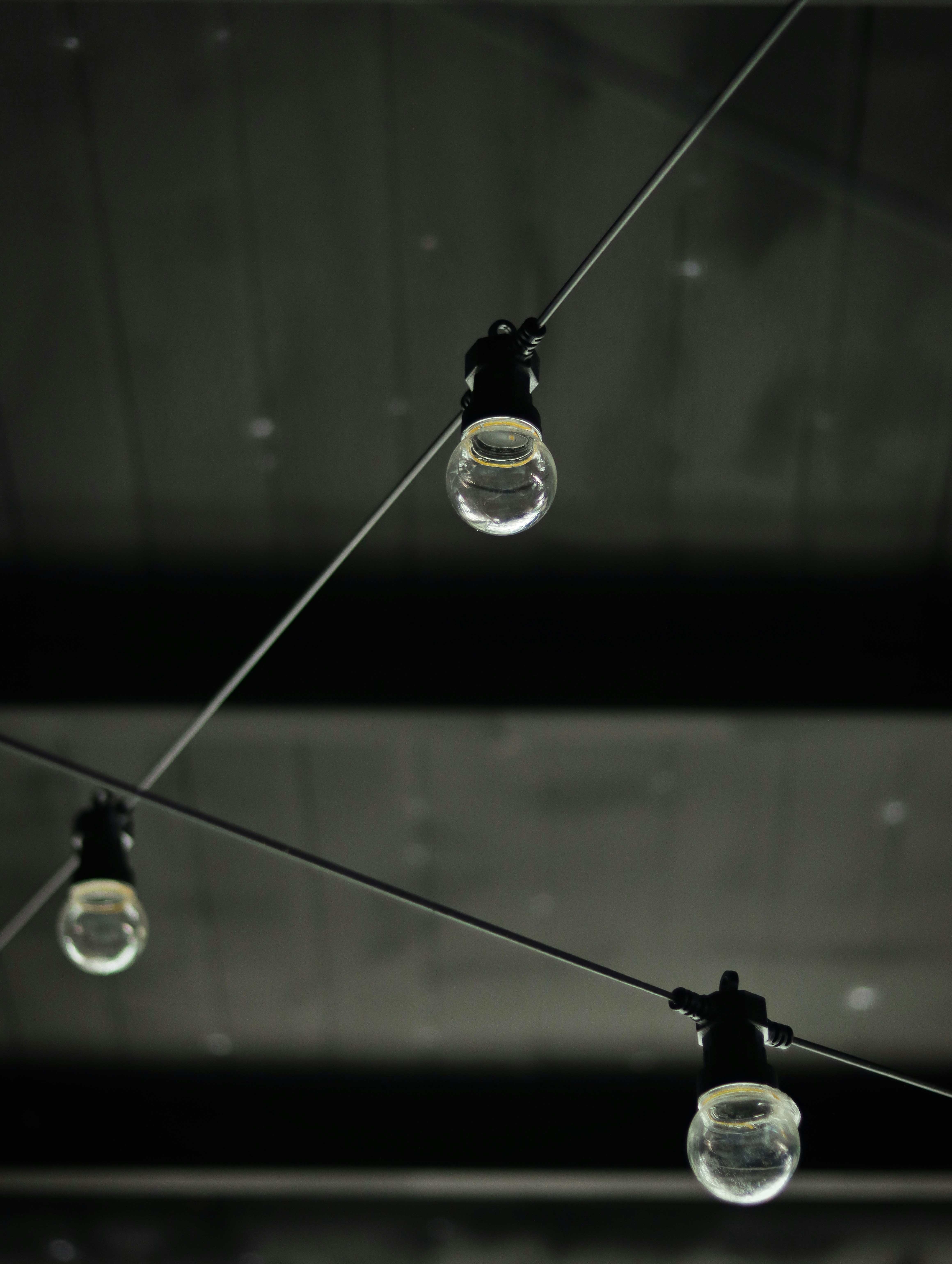Three hanging light bulbs suspended from a dark ceiling, creating a warm and inviting atmosphere.