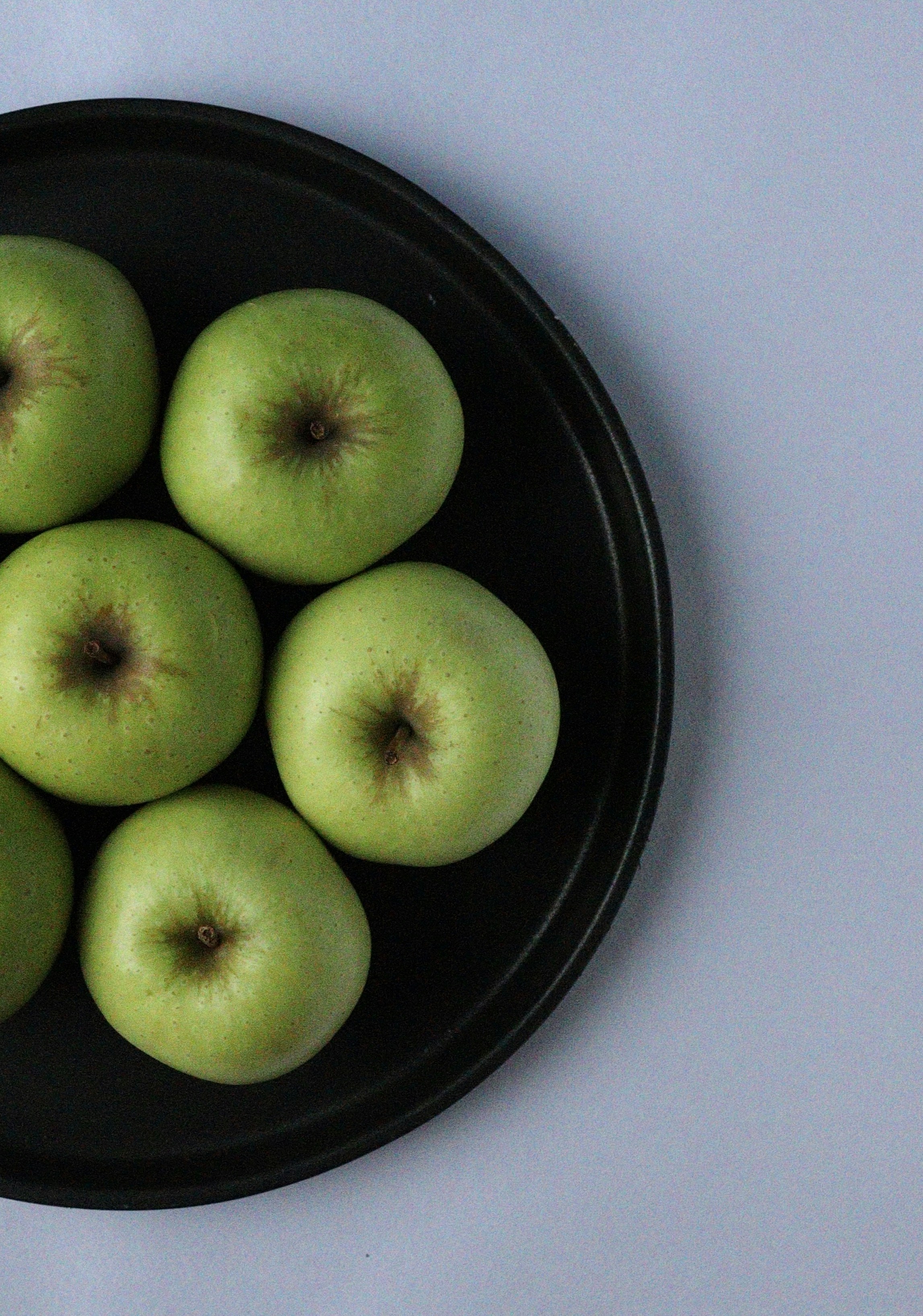Green apple fruits on black round plate photo – Free New delhi Image on ...