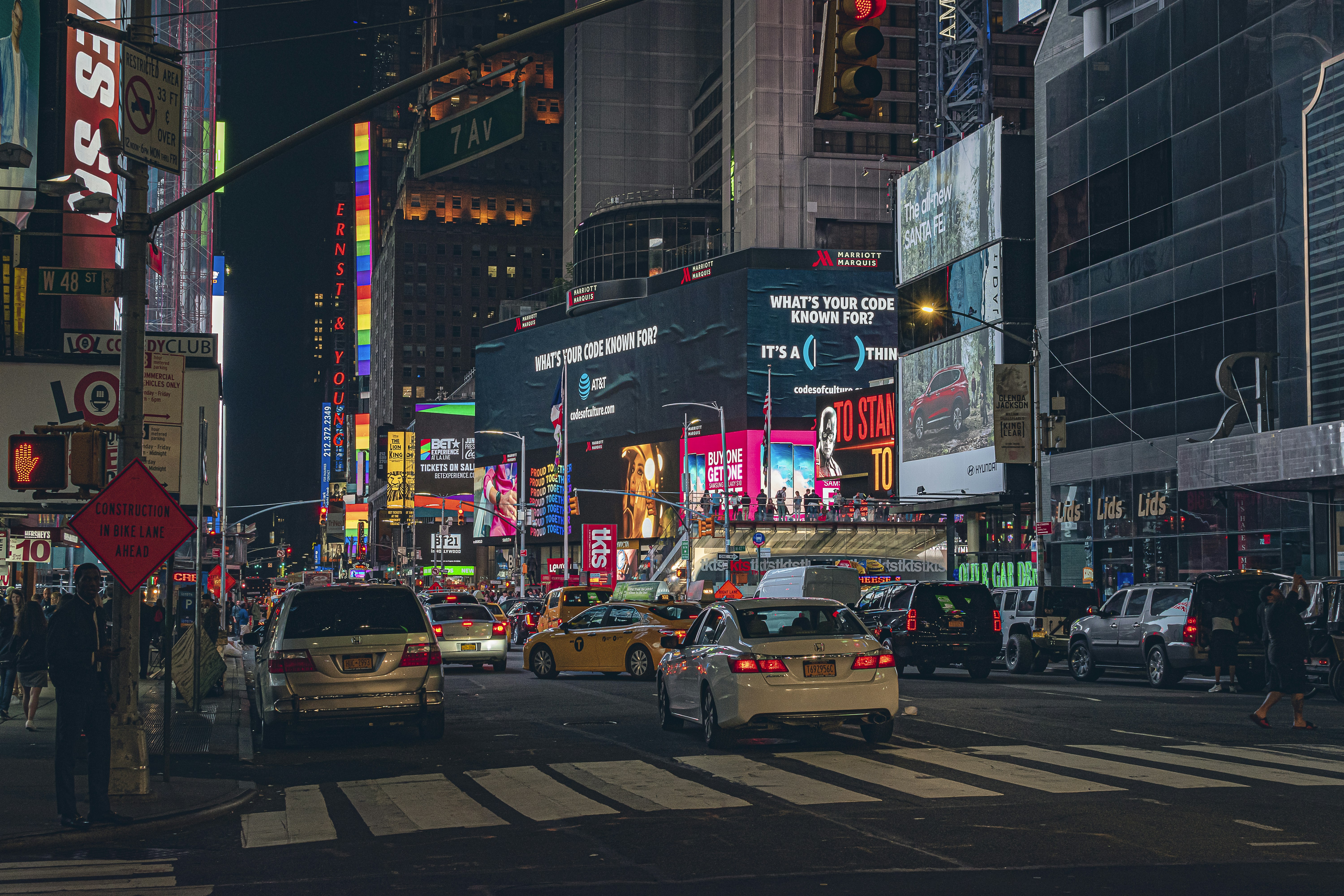 Vibrant Times Square scene featuring bustling traffic and illuminated billboards at night.