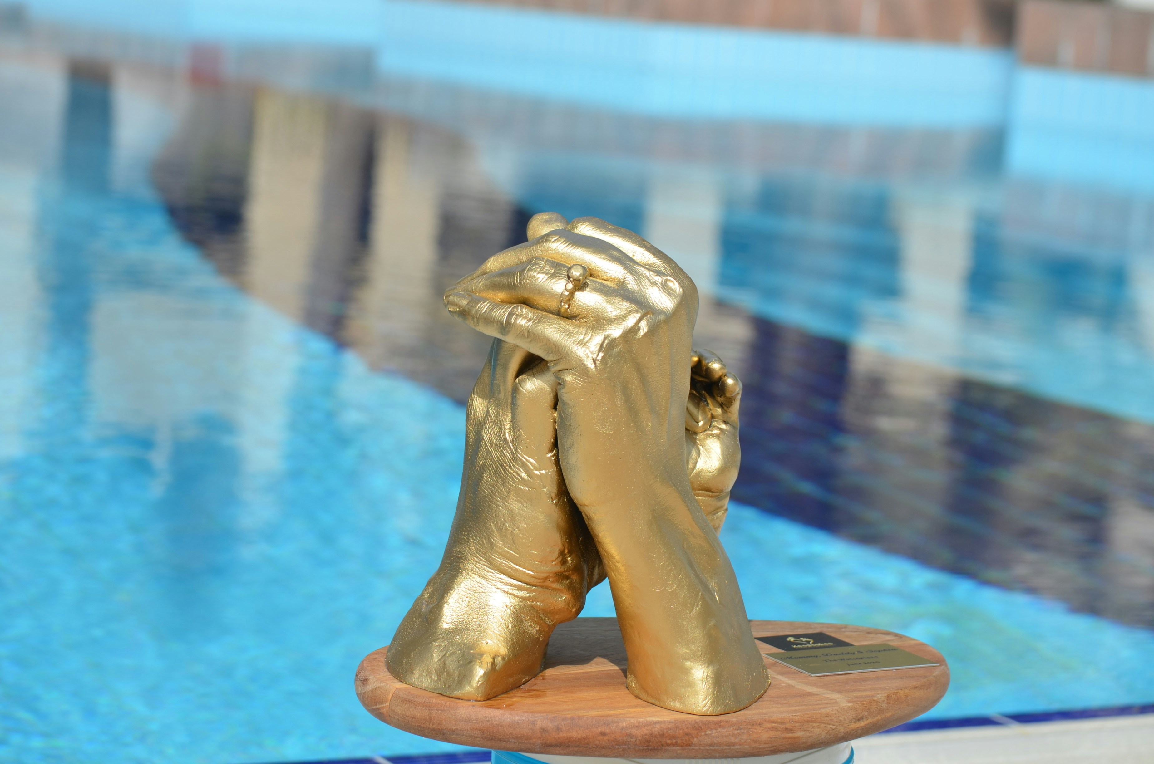 Golden Paired Hands in the Poolside Spotlight