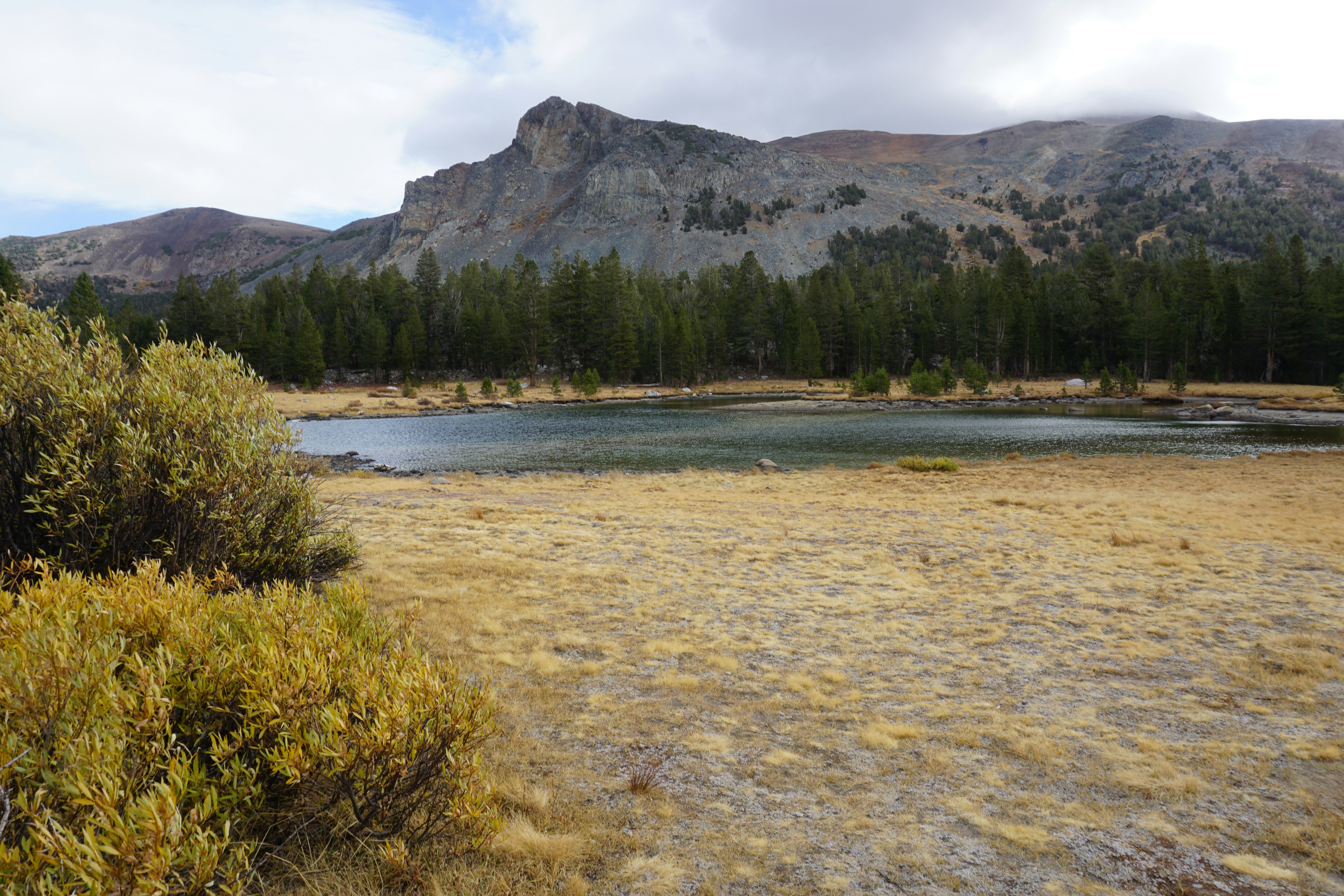 lake near trees surrounding by mountains