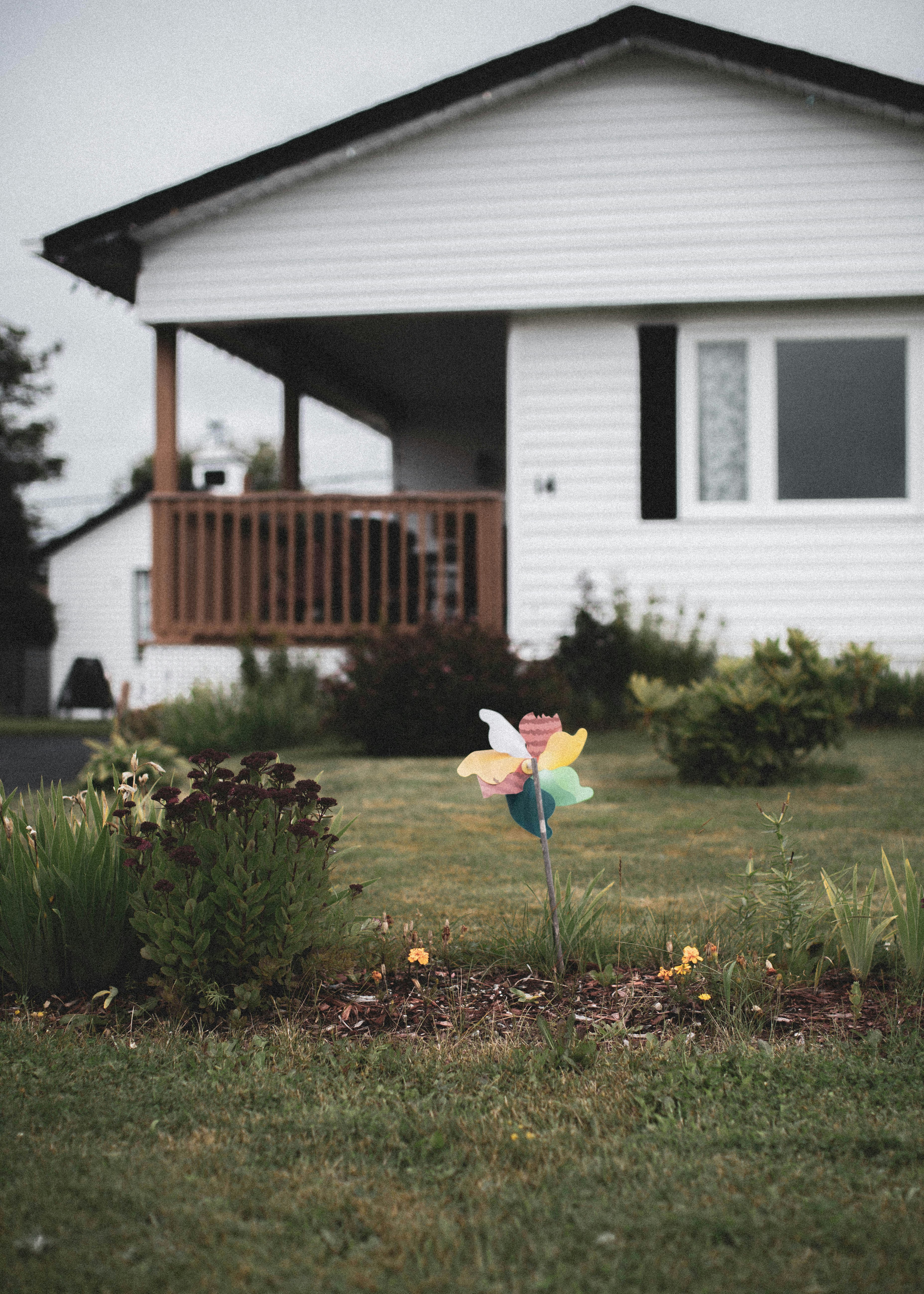 Colorful windmill in a tidy front yard before a small suburban home