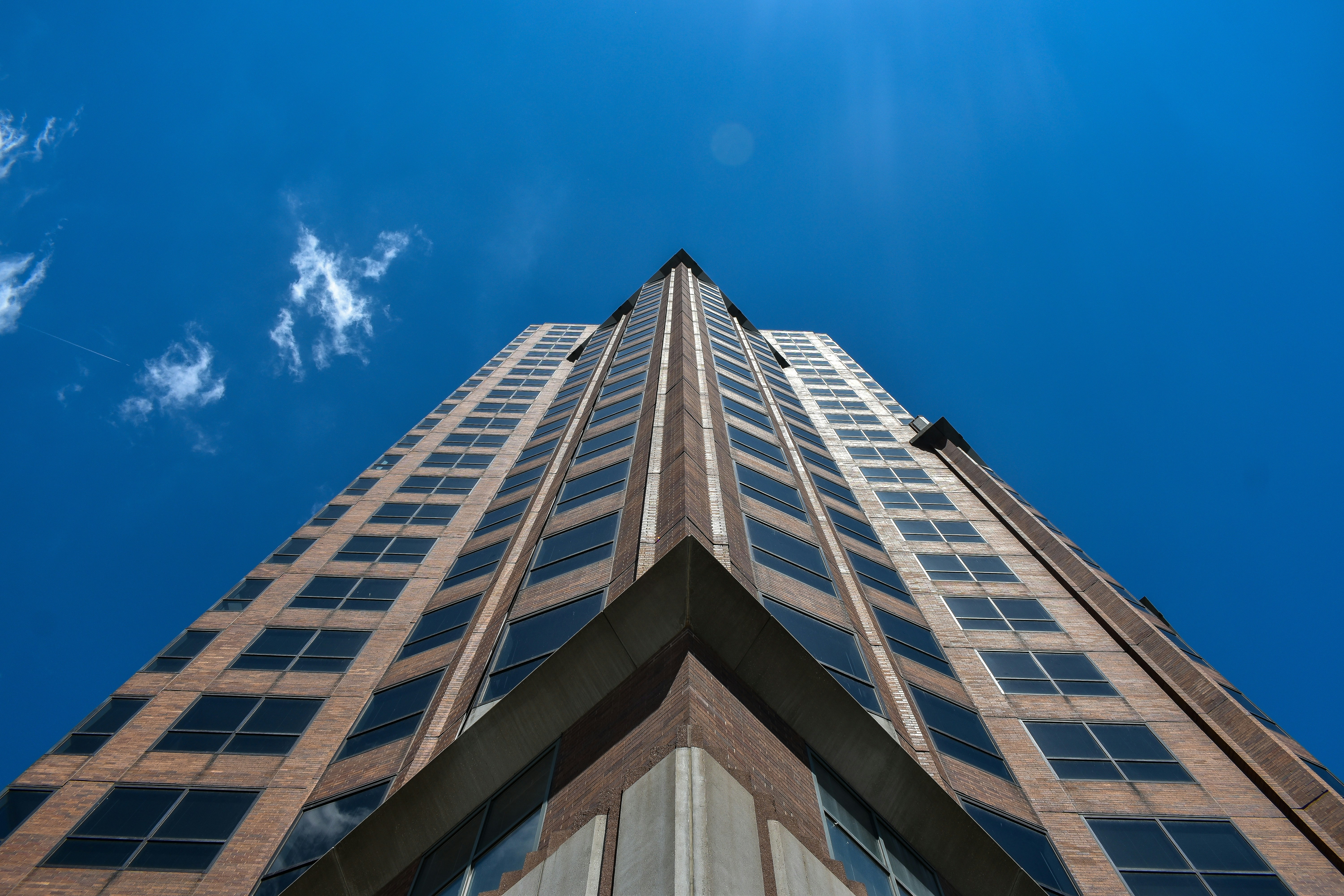 Low angle view of a high-rise building reaching into a clear blue sky.