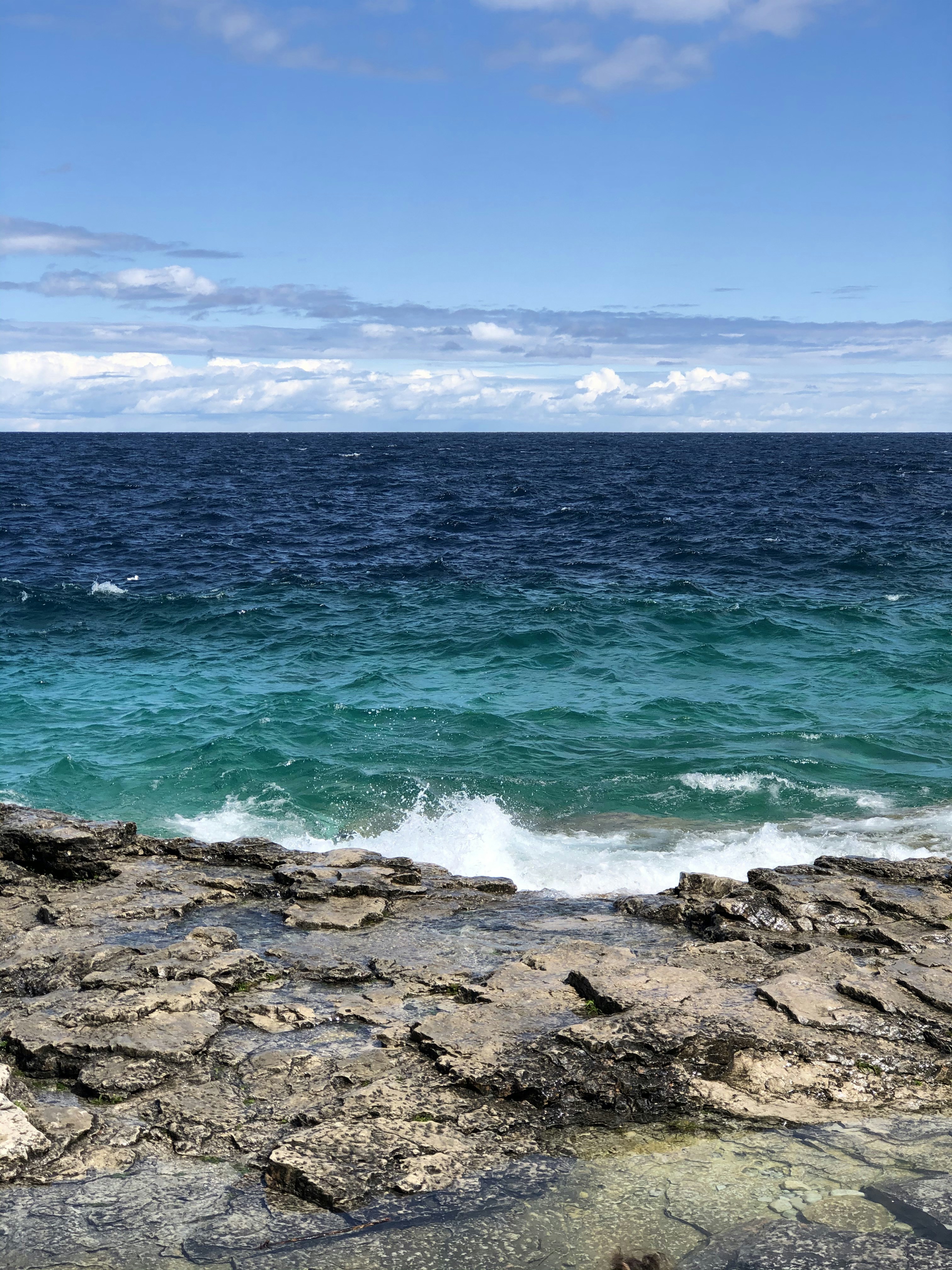 ocean waves crashing on rocky shore during daytime