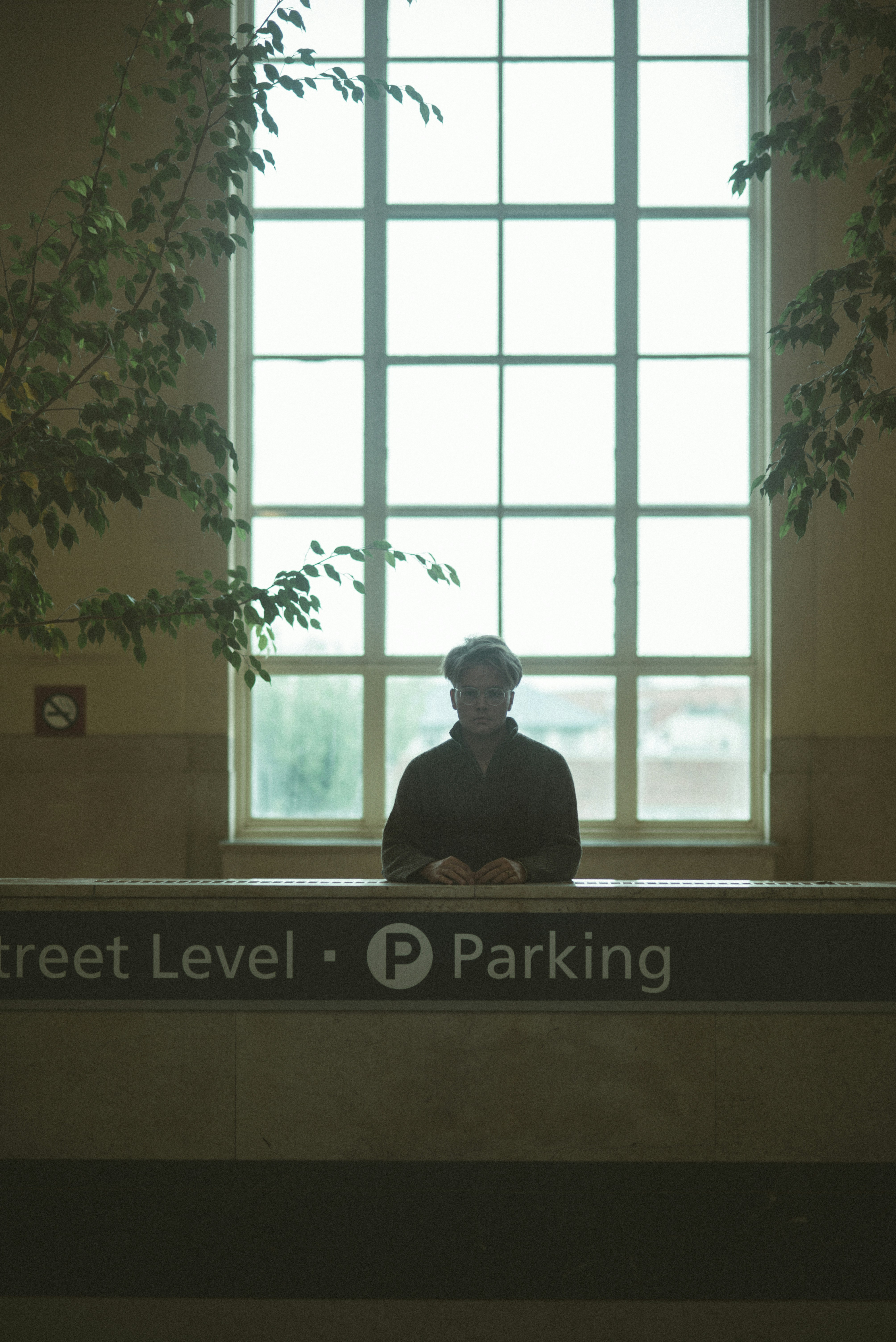 man in black jacket sitting on brown wooden bench