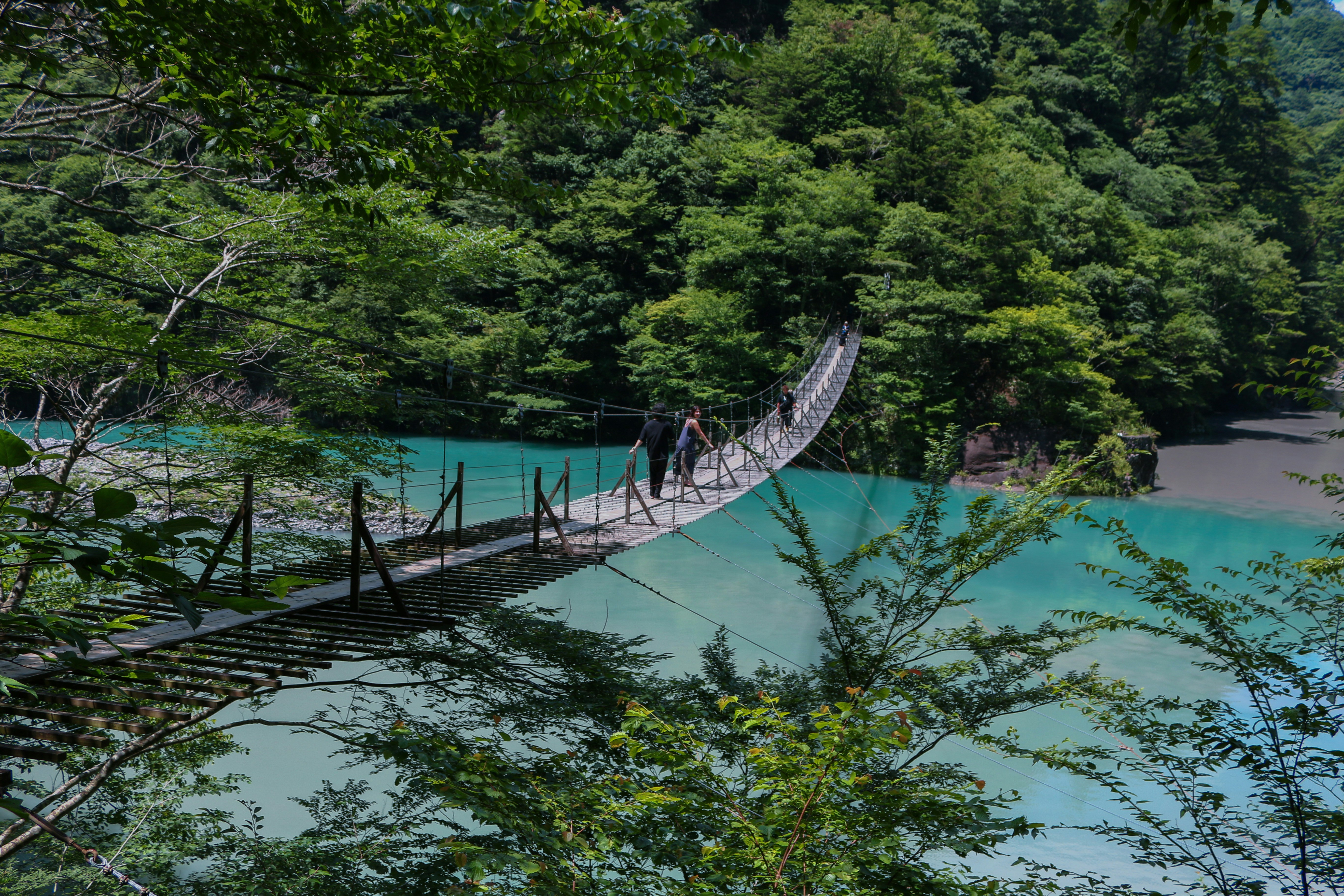 Two people crossing a bridge over a river photo – Free Kawanehon Image ...