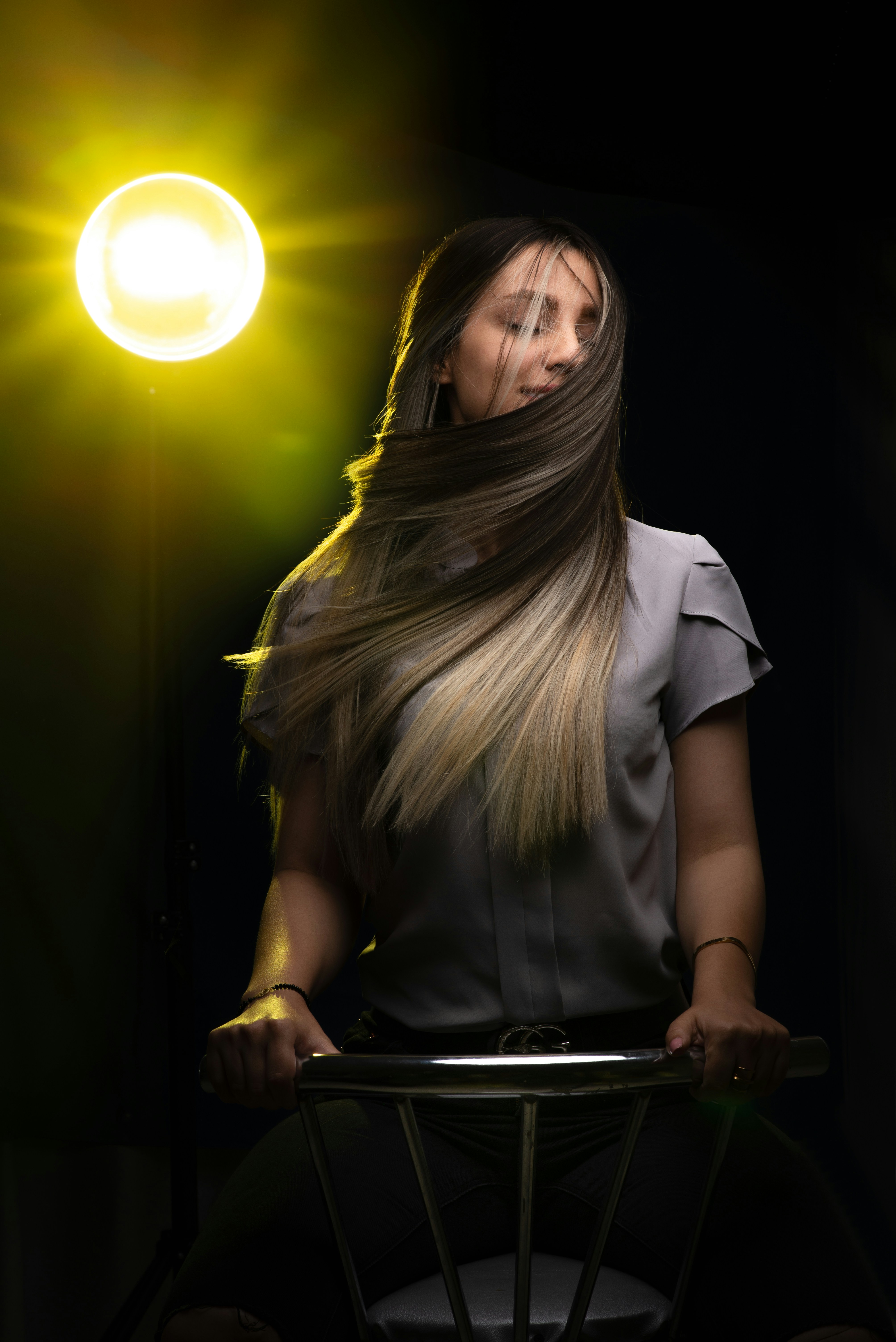 Hair in a Yellow Halo: Studio Portrait Beneath a Single Spotlight