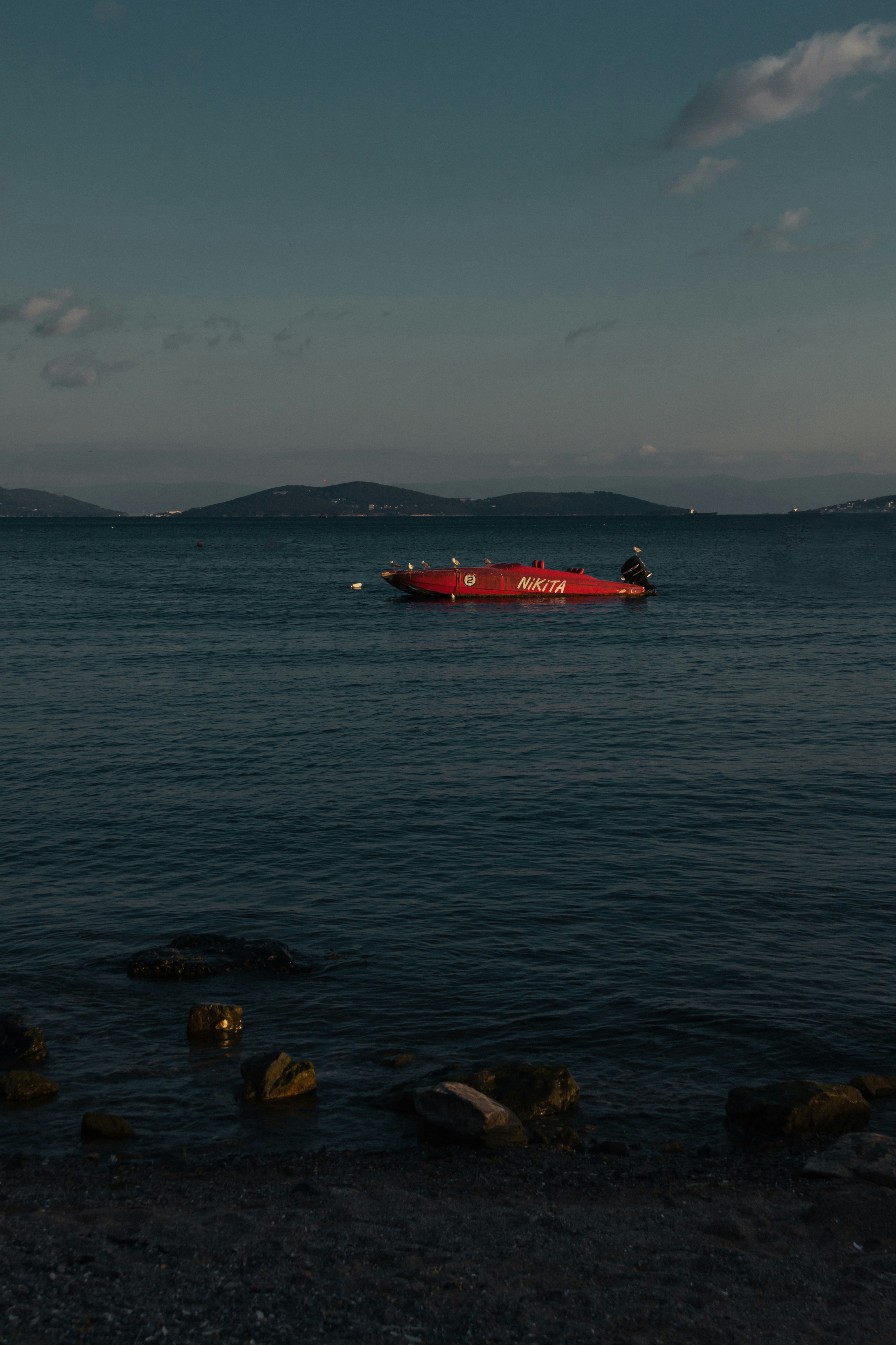 Red Boat on Quiet Blue: A Seascape with a Lone Vessel