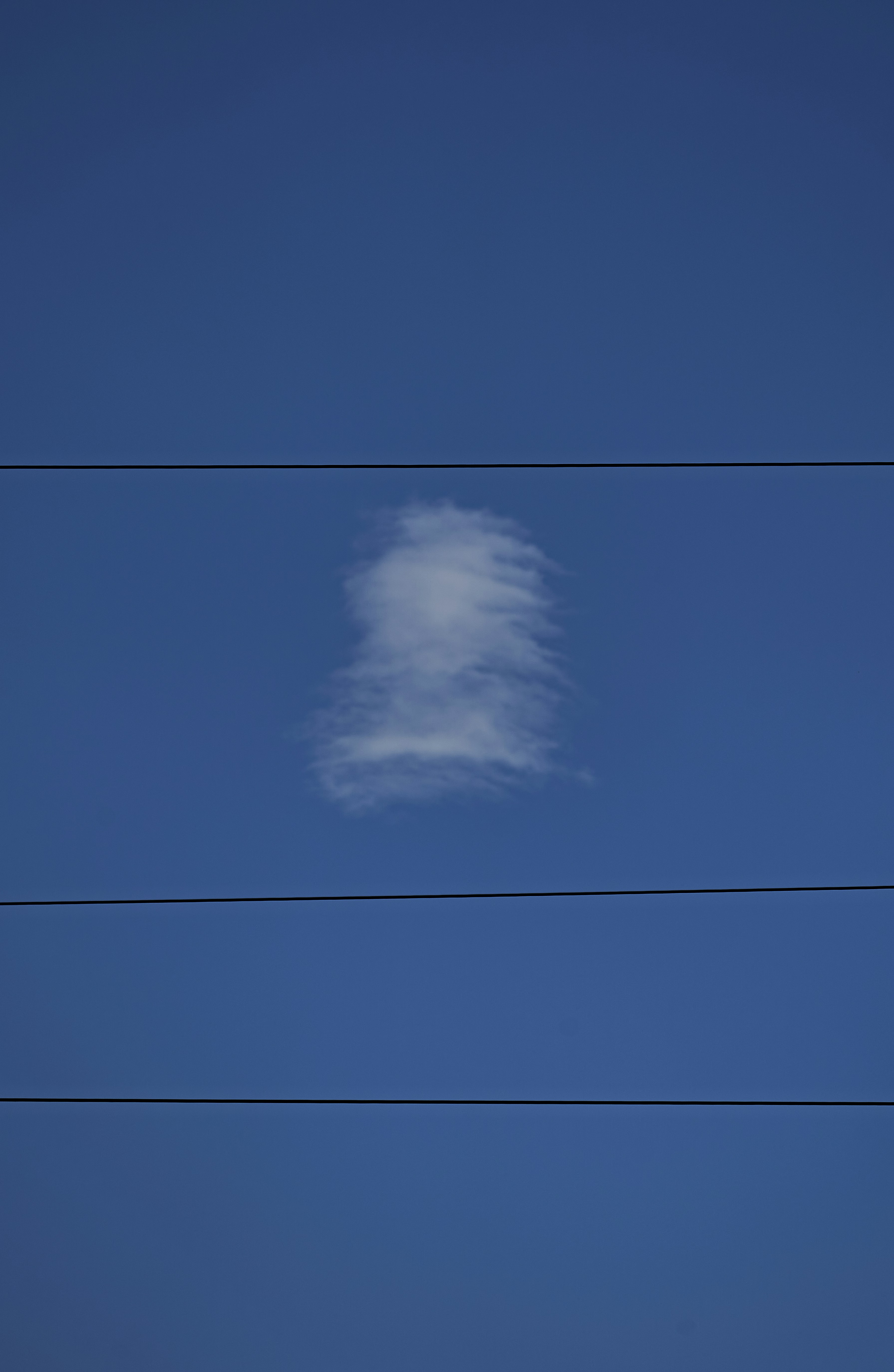 A cloud with an odd pattern seen through power lines