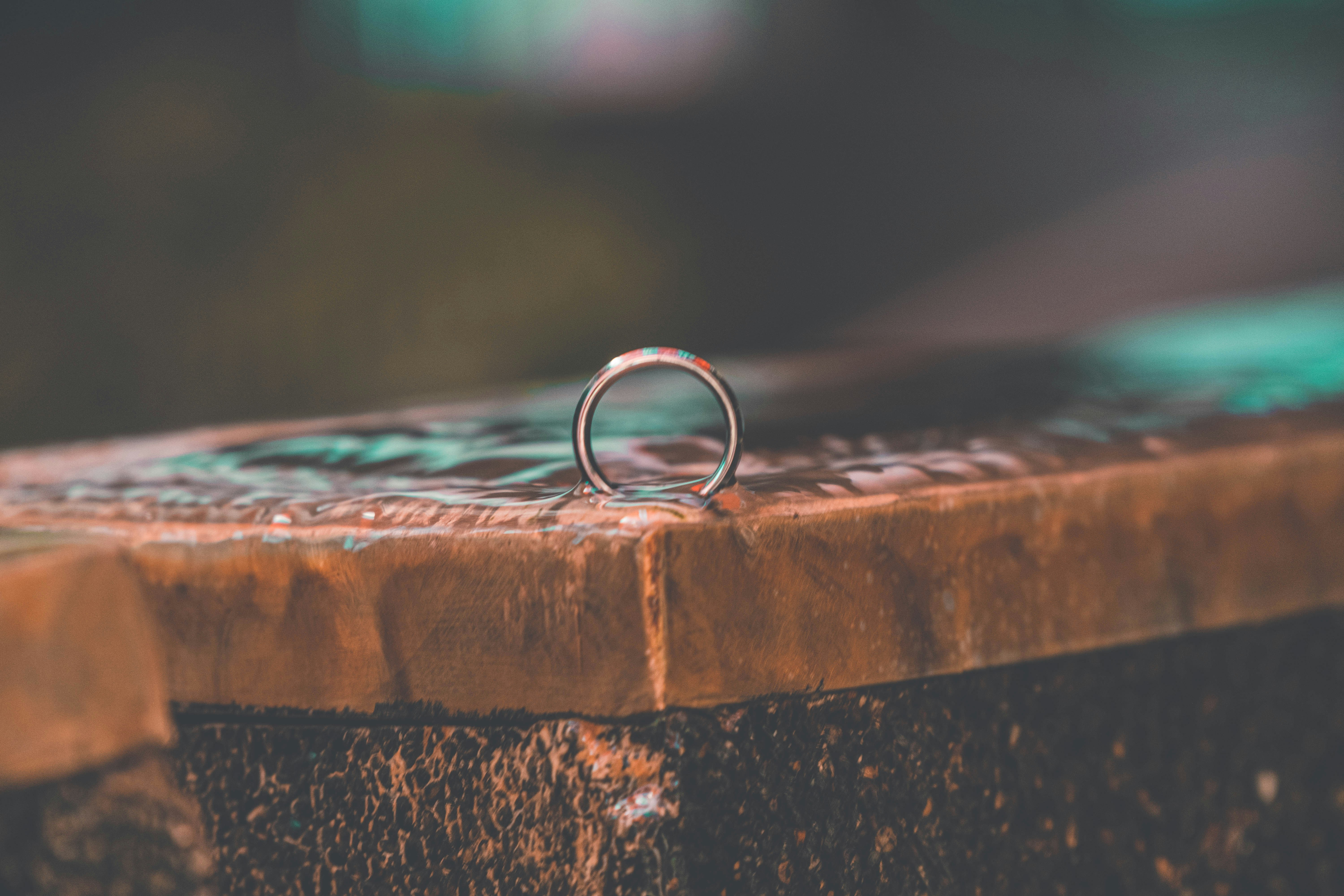 silver ring on brown wooden table