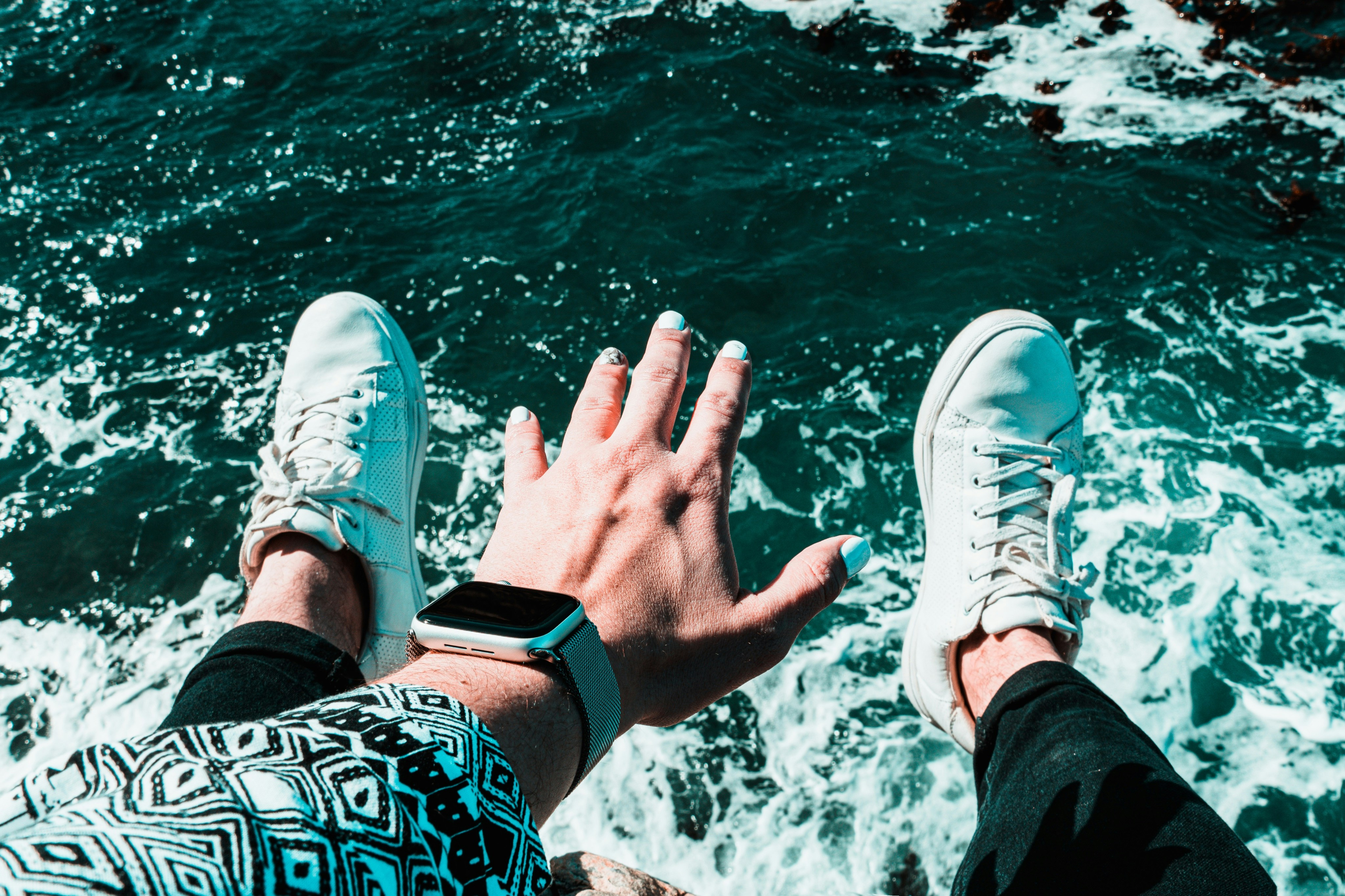 Over the Edge: Turquoise Sneakers Above the Ocean's Foam