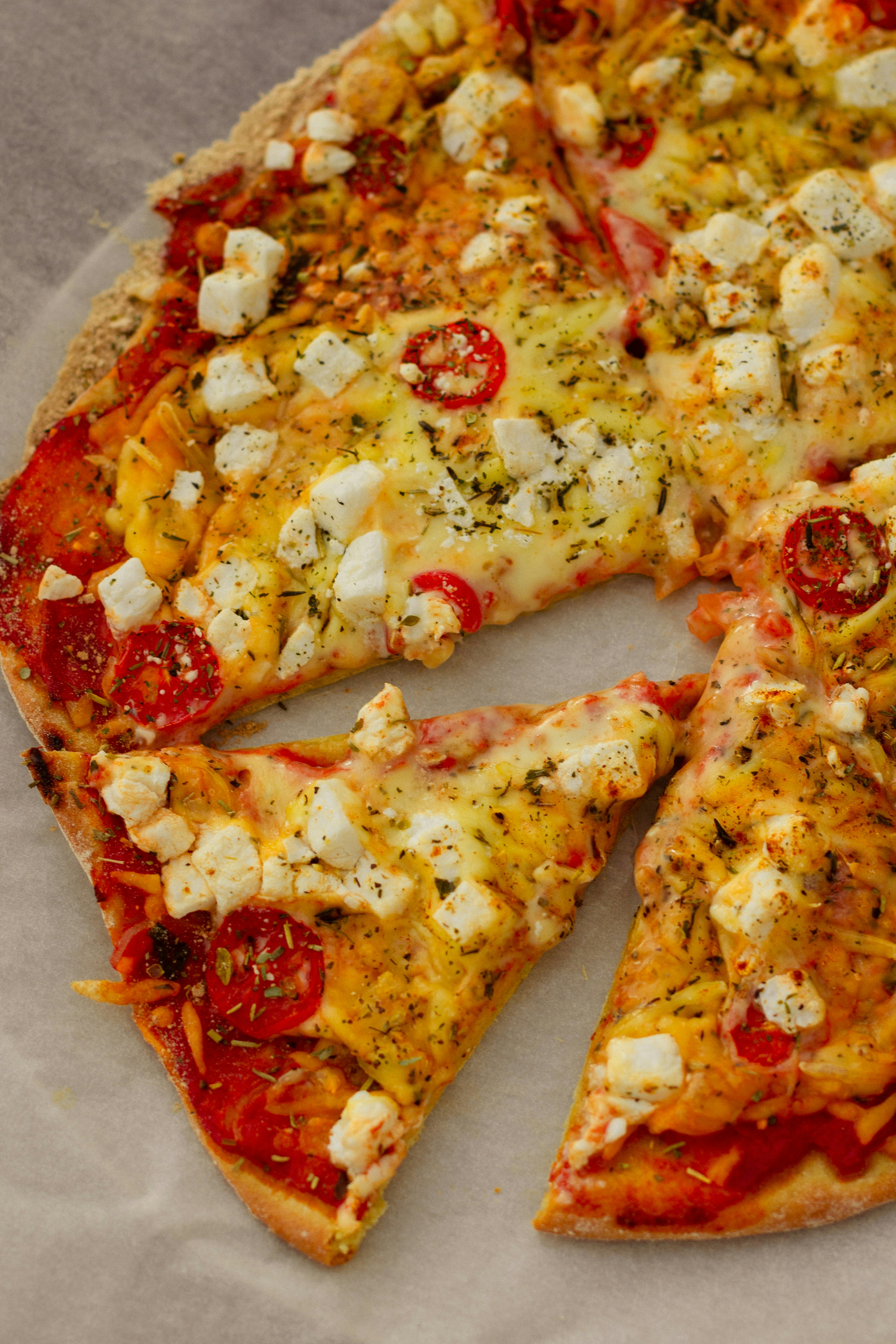 Deliciously topped pizza with vibrant tomatoes and creamy cheese, showcasing a golden crust and fresh herbs.