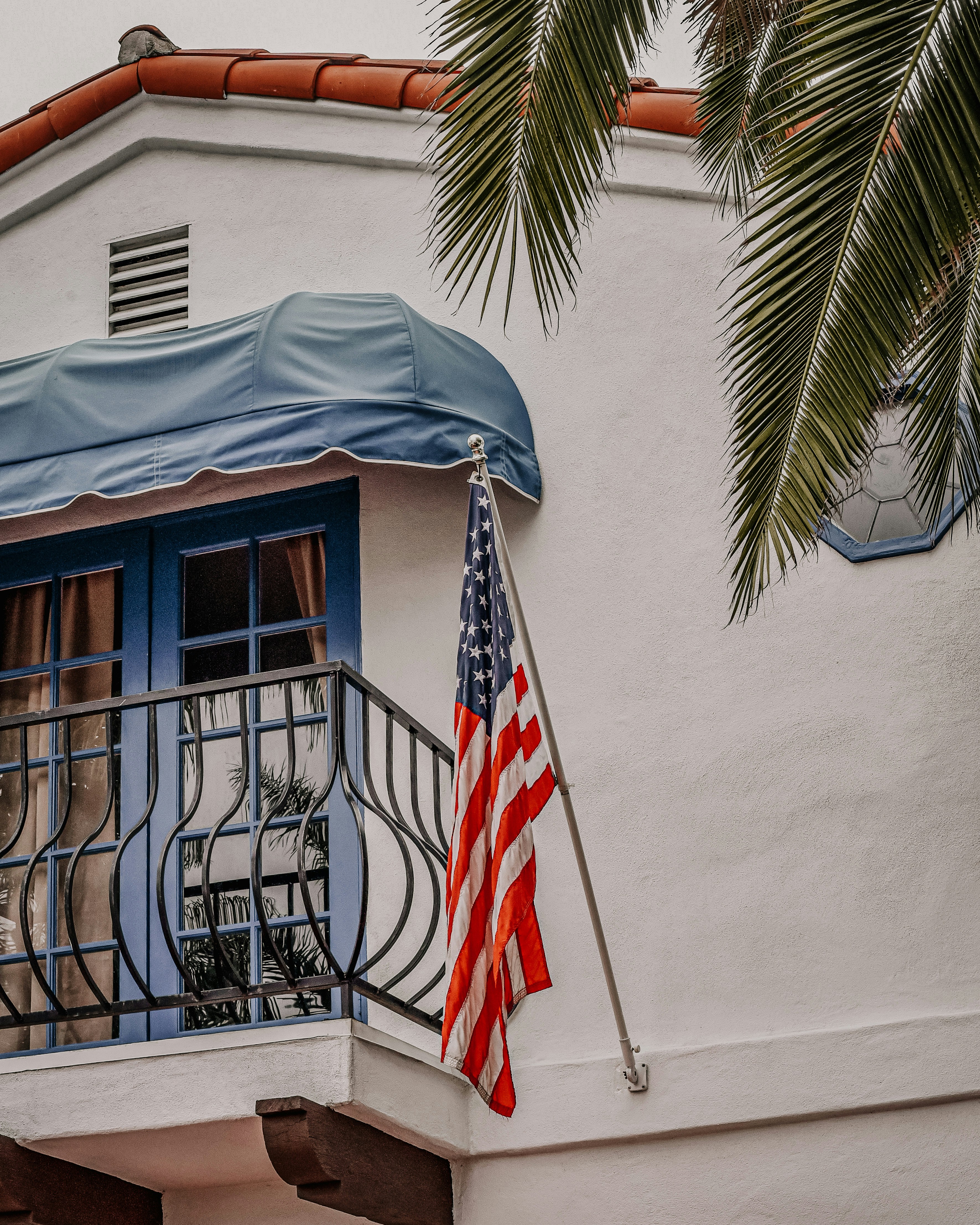 Flag Over the Balcony: A Florida Terrace Framed by Palm Fronds