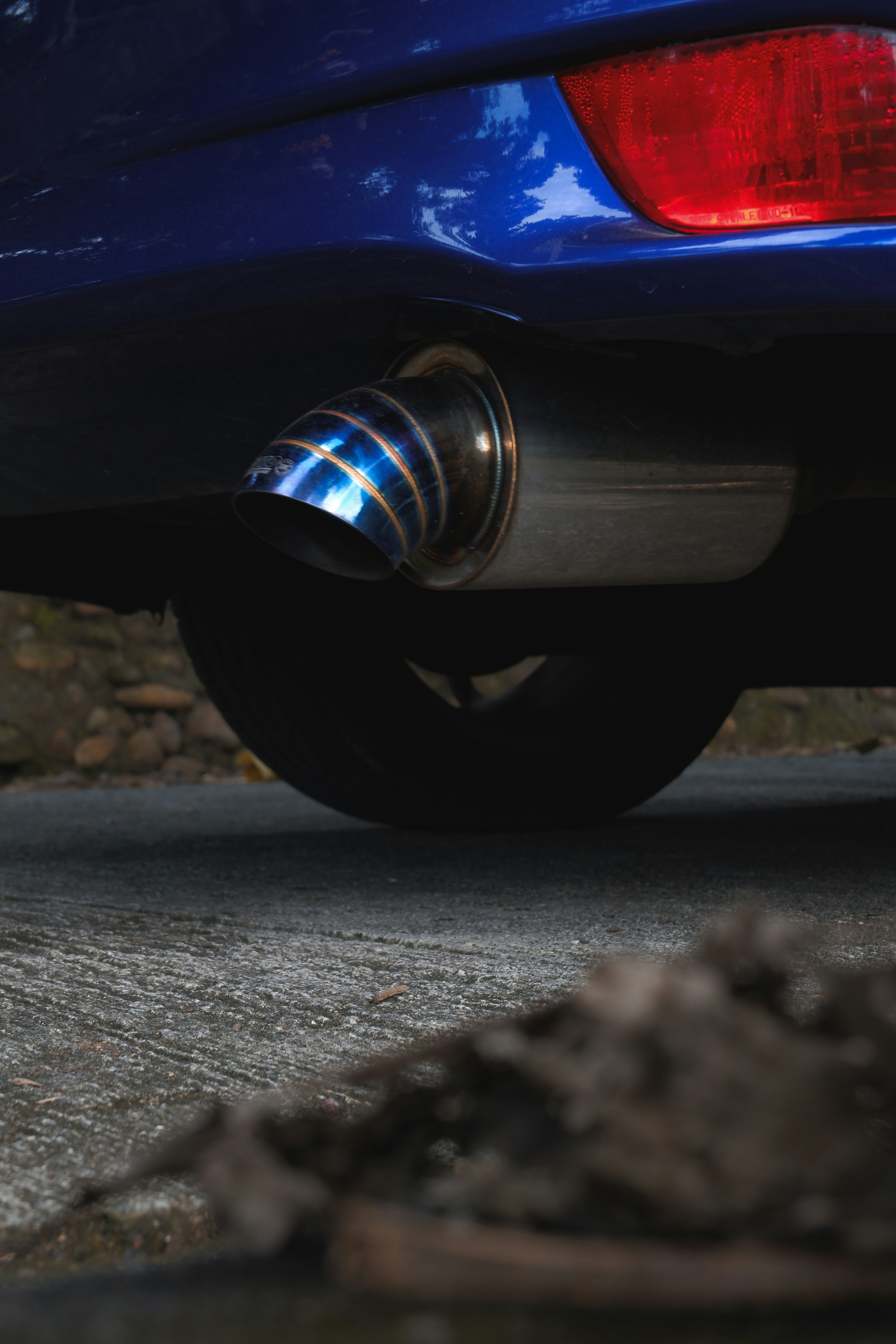 Chrome Tailpipe Glow Beneath a Blue Coupe